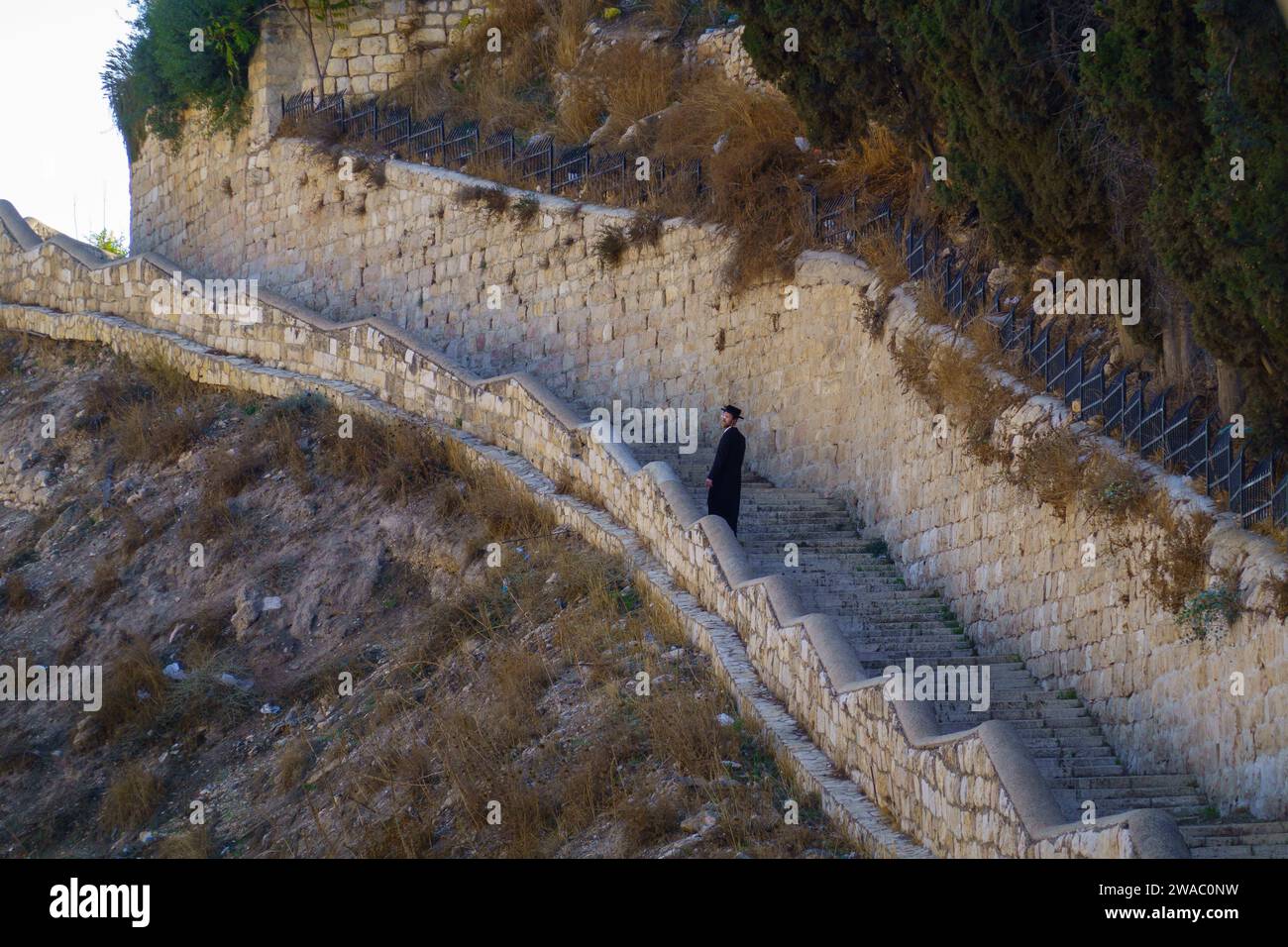Orthodox Jew in traditional attire descends ancient stone steps in ...