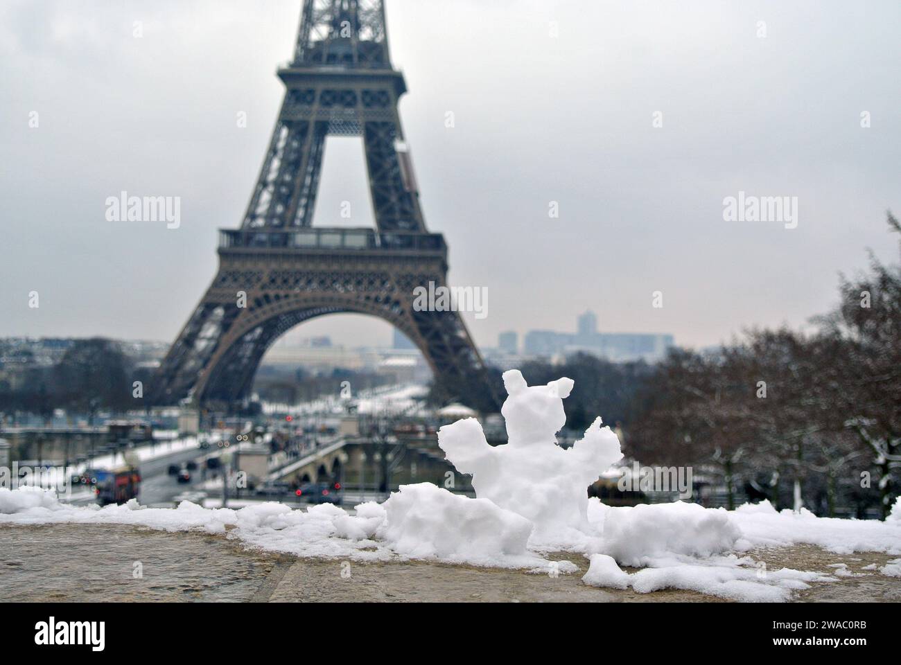 Unexpected snow in Paris. Snowman and melting snow on the parapet of ...