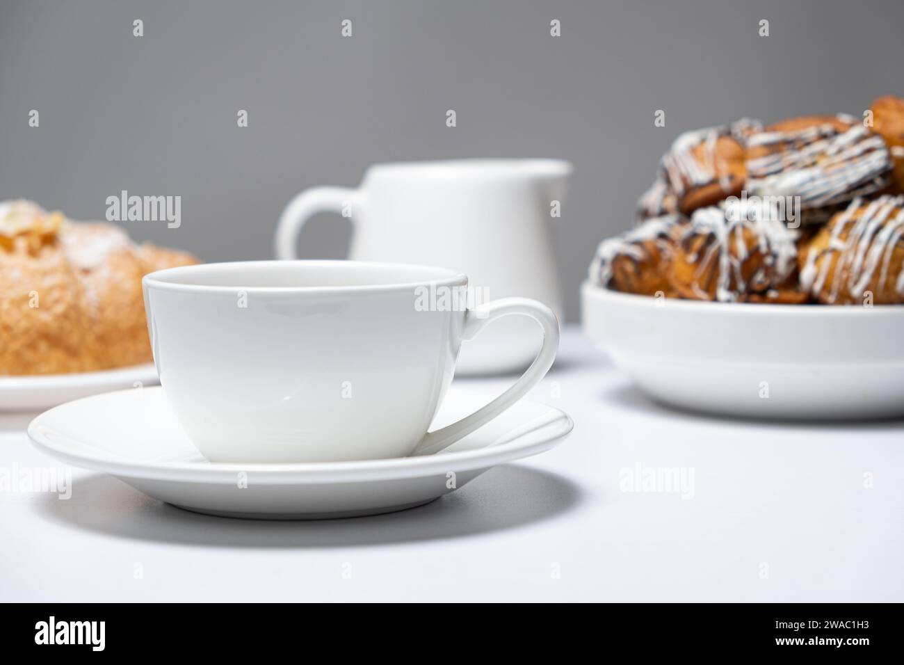 Breakfast utensils. An empty coffee cup, a milk jug and plates of ...