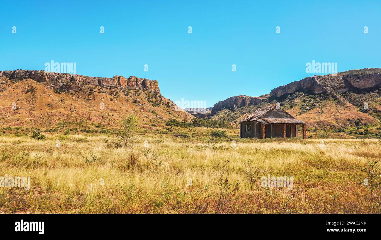 Low grass growing on African savanna, small rocky mountains in ...