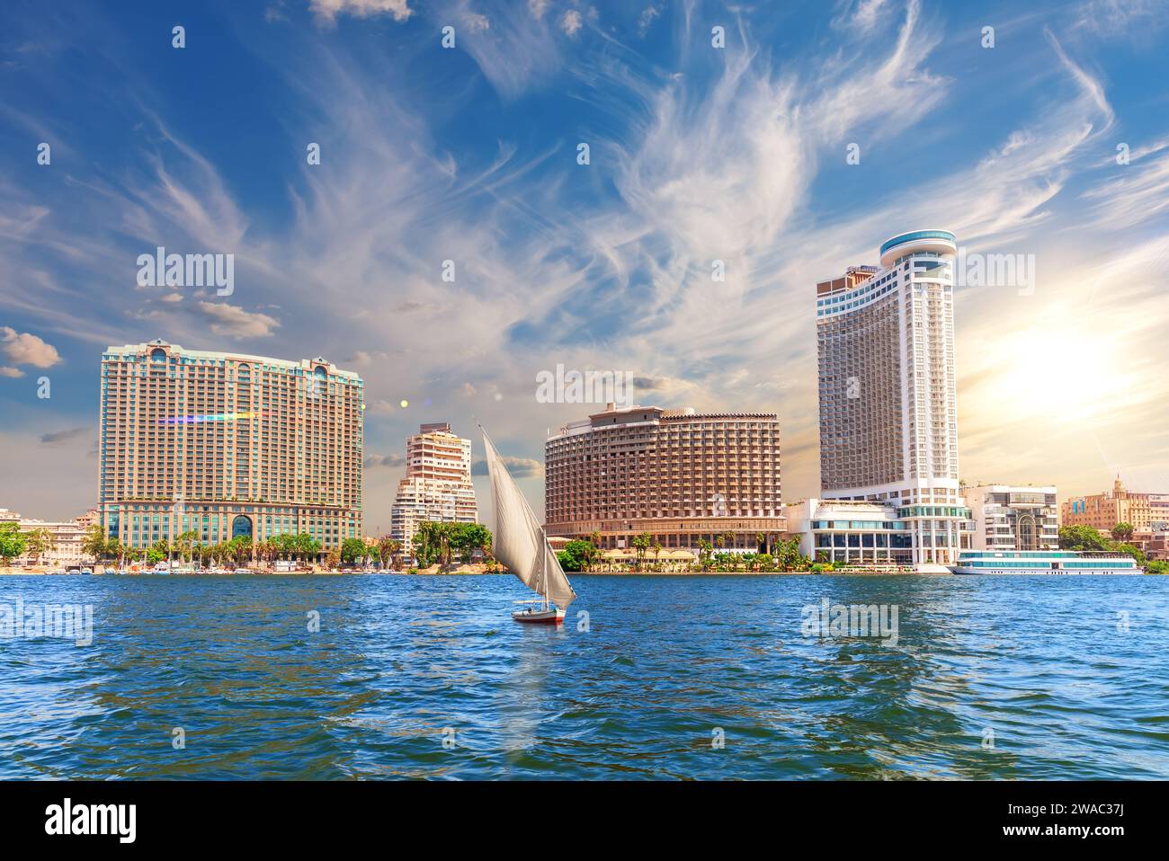 Nile river with a boat by the luxurious buildings of modern Cairo ...