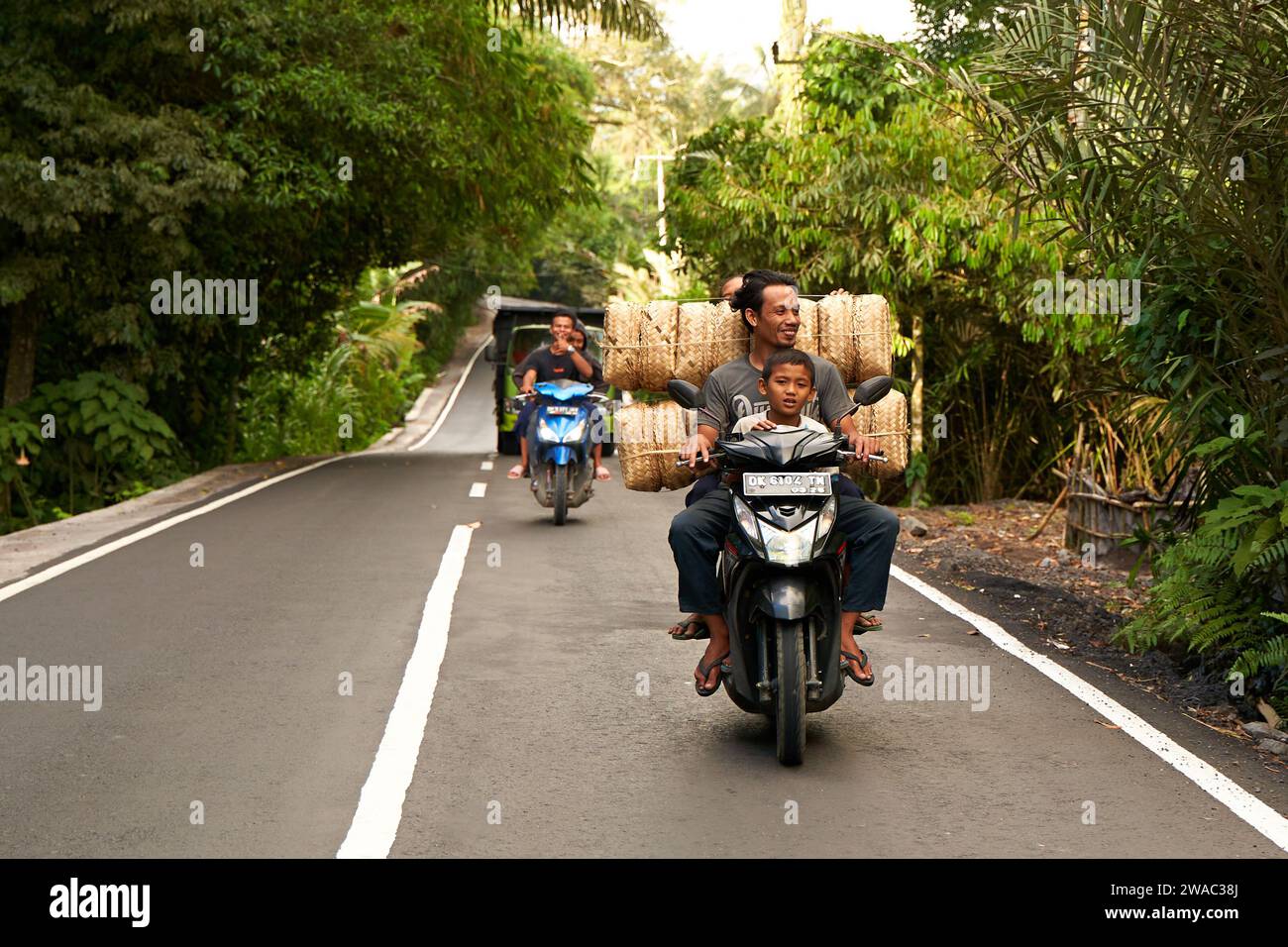 People are riding a heavily loaded motorcycle. Asian people are ...