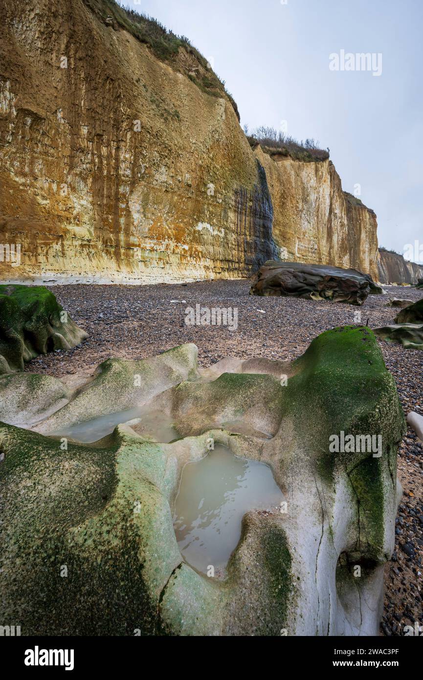 Rocks shaped by the sea on a pebble beach with chalk cliffs Stock Photo ...