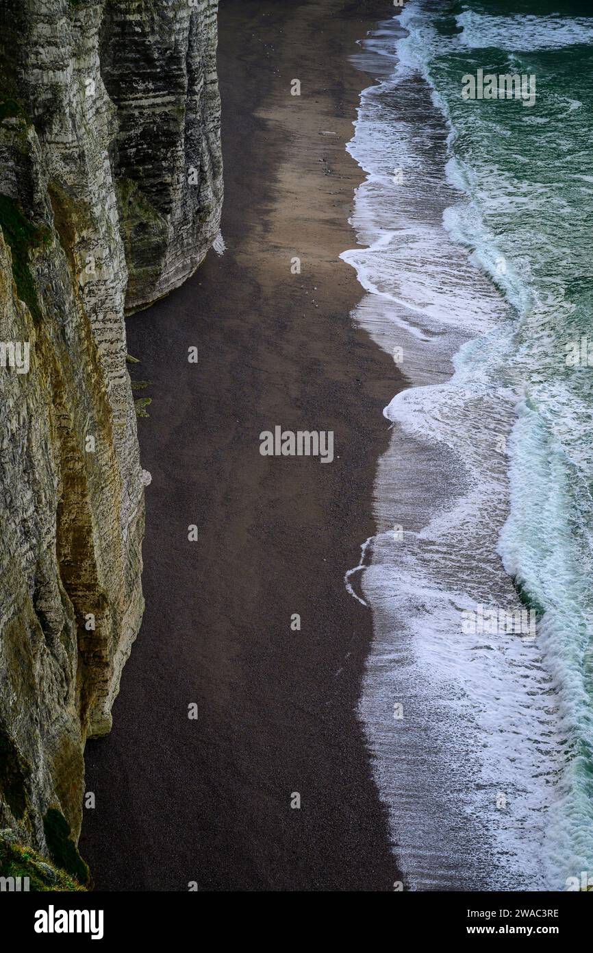 Black pebble beach with chalk cliffs and white waves Stock Photo - Alamy