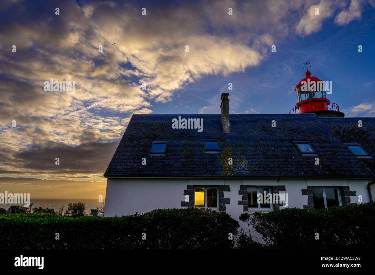 Lighthouse with a sunset sky shining through a window of the building ...