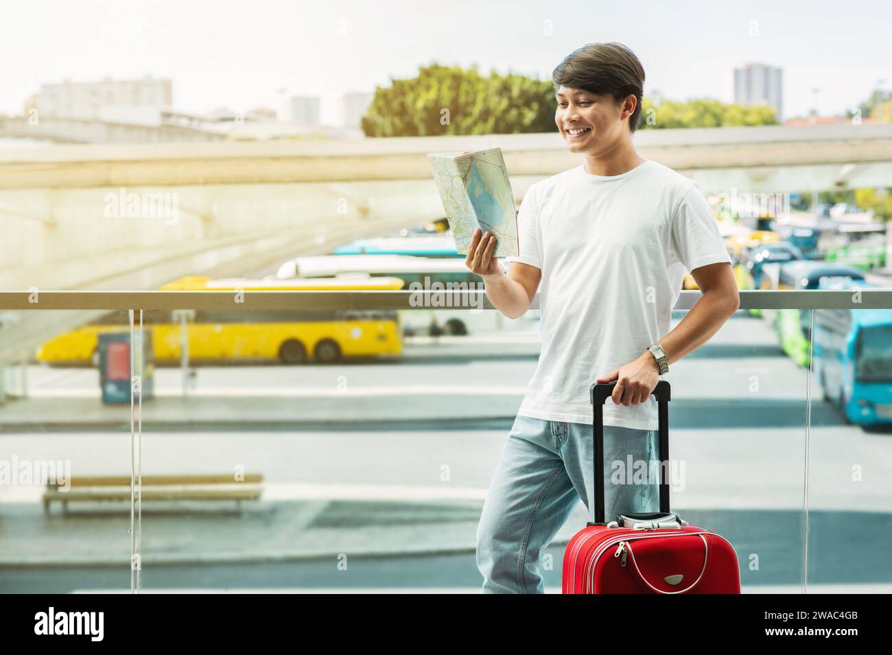 Young asian guy tourist checking paper map Stock Photo - Alamy