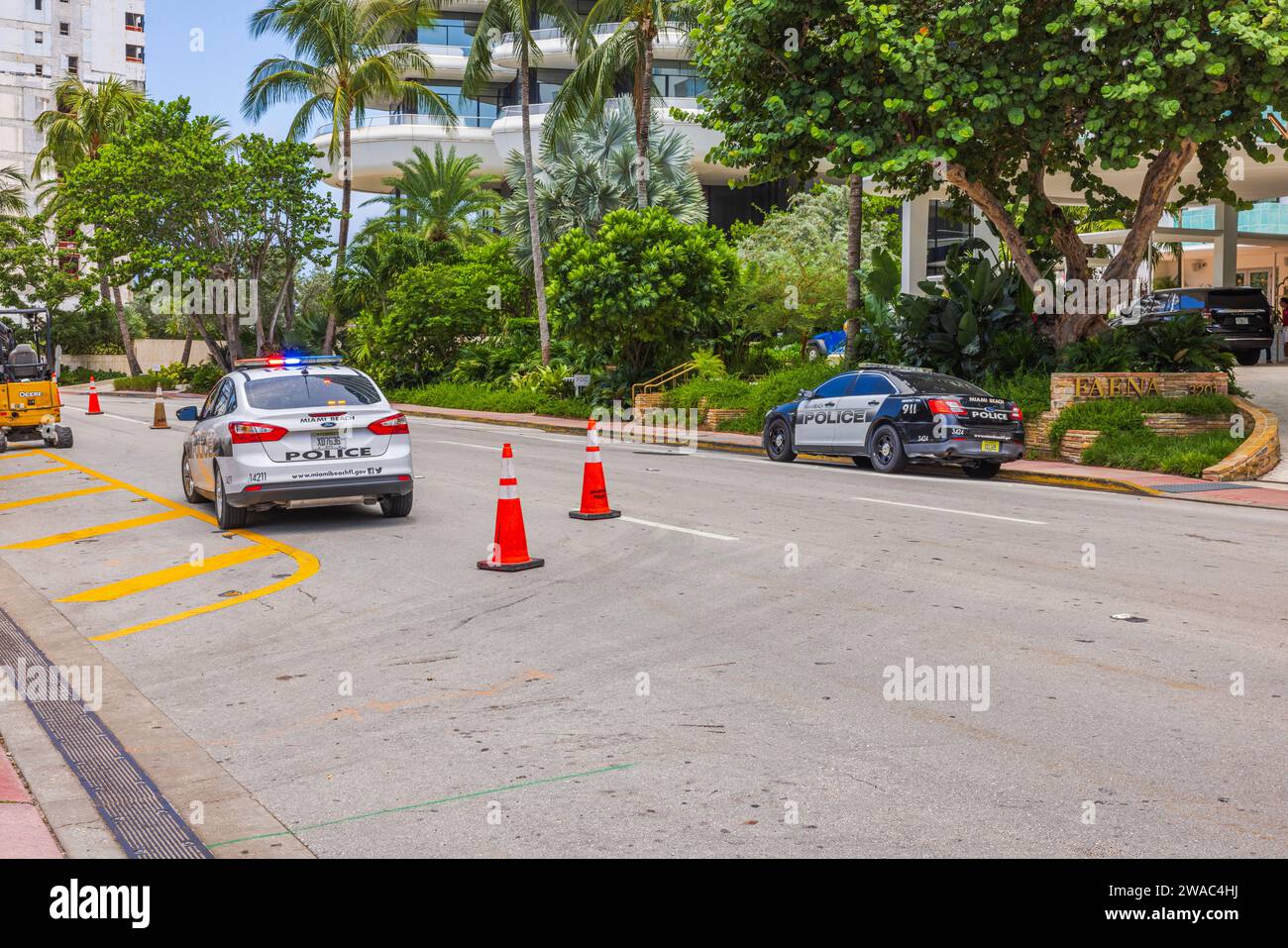 View of police cars with rooftop lights parked on Collins Avenue near ...