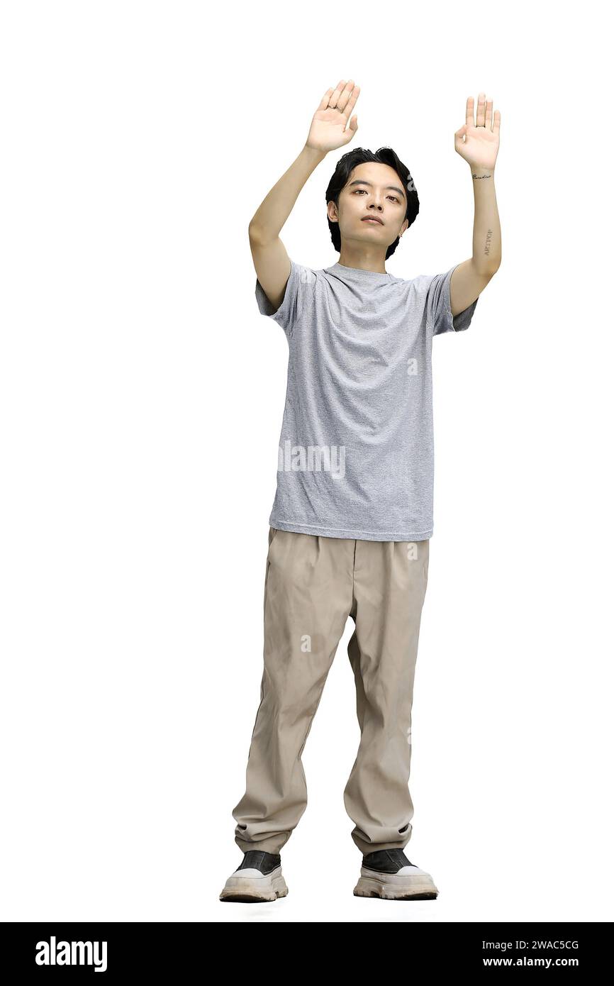 A guy in a gray T-shirt, on a white background, in full height, raised ...
