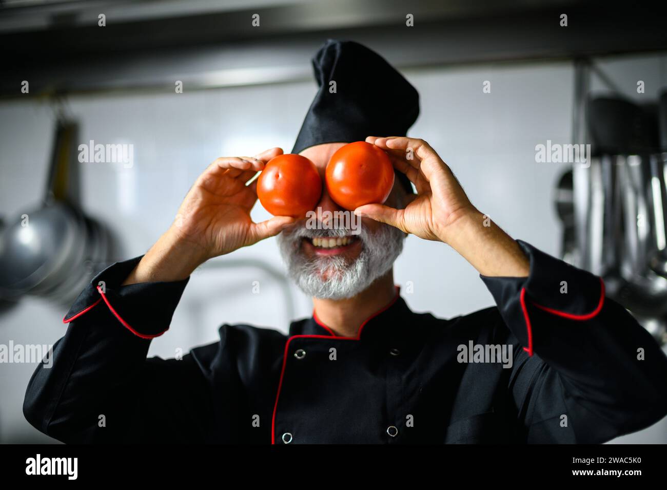 Funny chef covering his eyes with tomatoes Stock Photo - Alamy