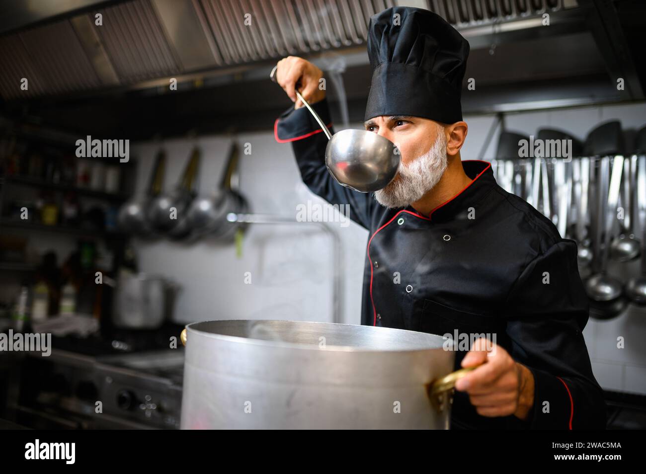 Chef tasting a soup from a mastol Stock Photo - Alamy