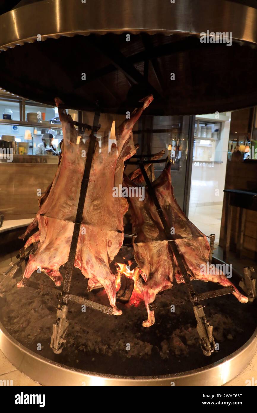 lamb cooking on an open fire aka Lamb al asador in a El Chalten ...
