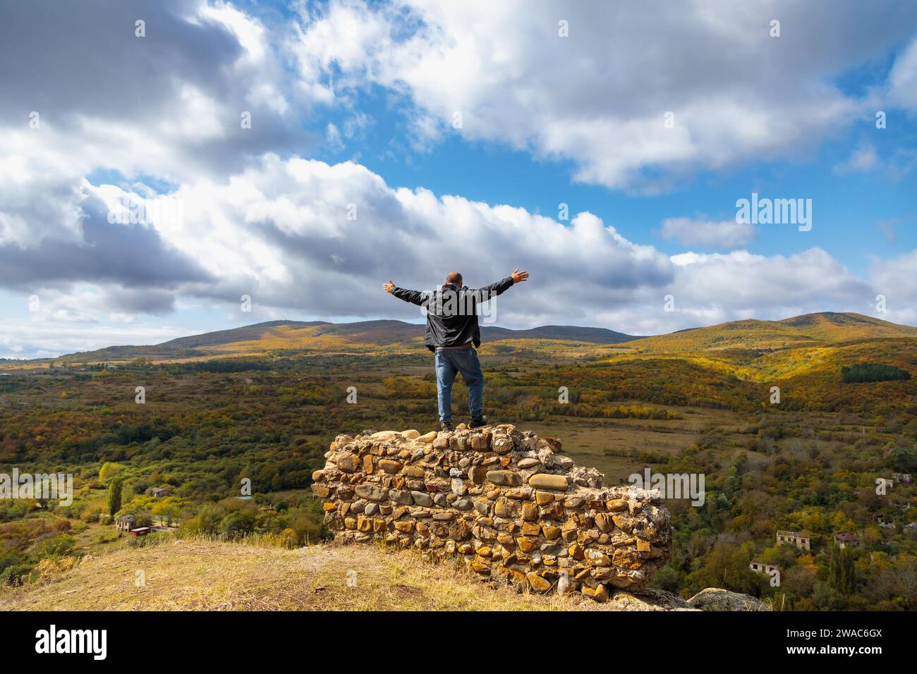 Man standing on a crumbling fortress wall, gazing at a stunning ...