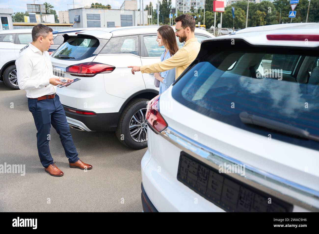 People inspect a car in the yard of a car dealership Stock Photo - Alamy