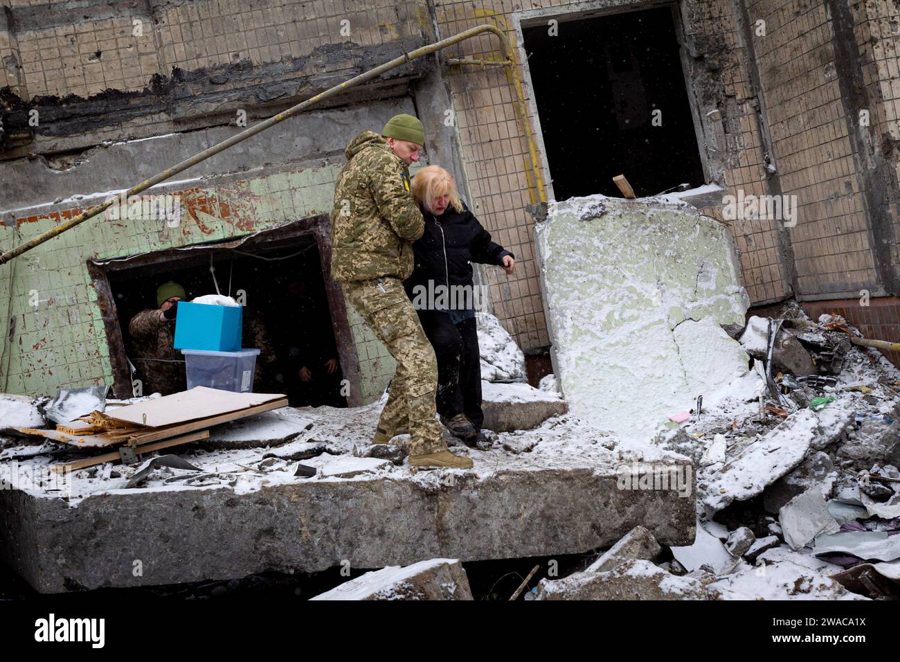 Non Exclusive: KYIV, UKRAINE - JANUARY 3, 2024 - A serviceman helps a ...
