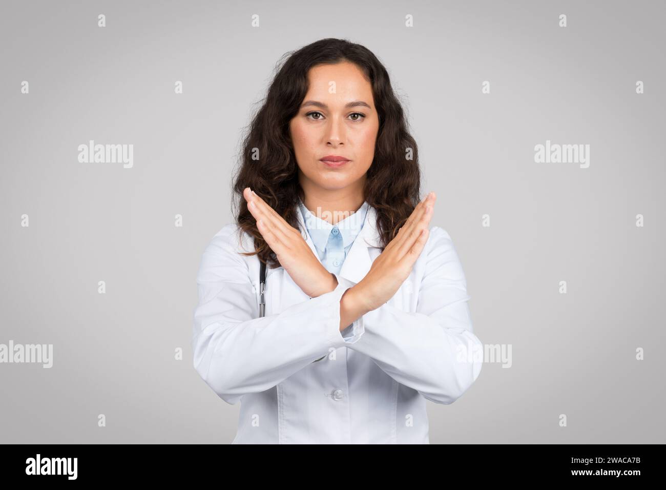 Doctor woman making 'no' sign with her arms crossed Stock Photo - Alamy