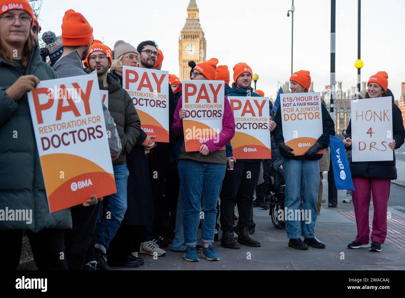 London, UK. 03rd Jan, 2024. Protesters hold placards expressing their ...