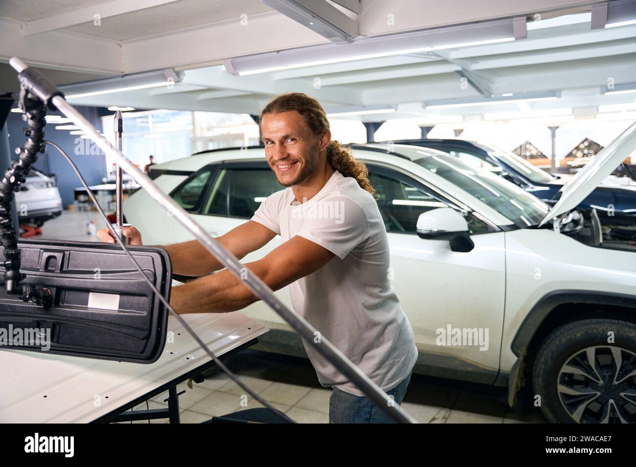 Specialist is working on straightening a white car Stock Photo - Alamy