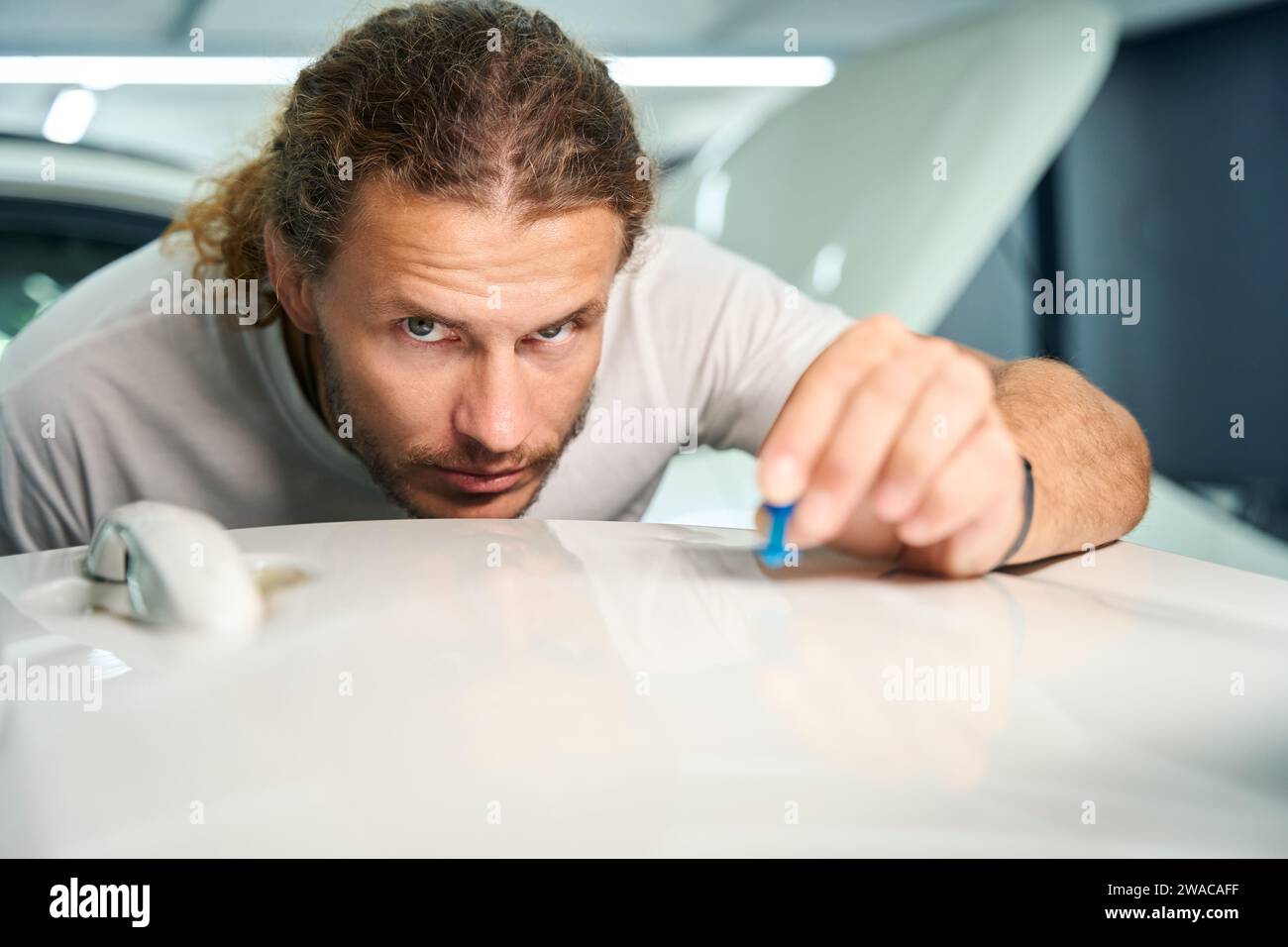 Master repairs the door of a white car Stock Photo - Alamy
