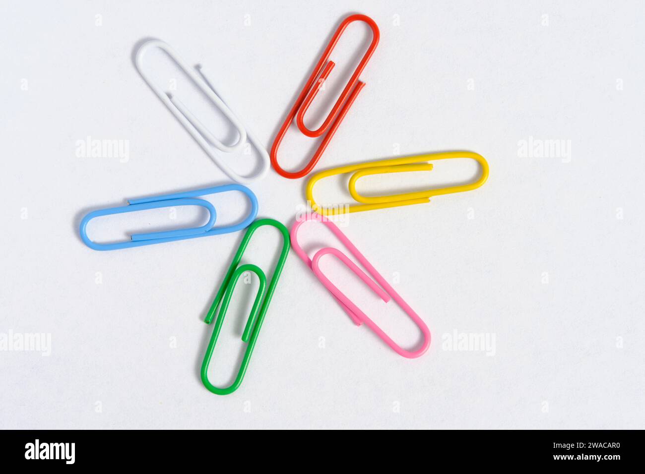 Multi colored paper clips are folded in shape star white background ...