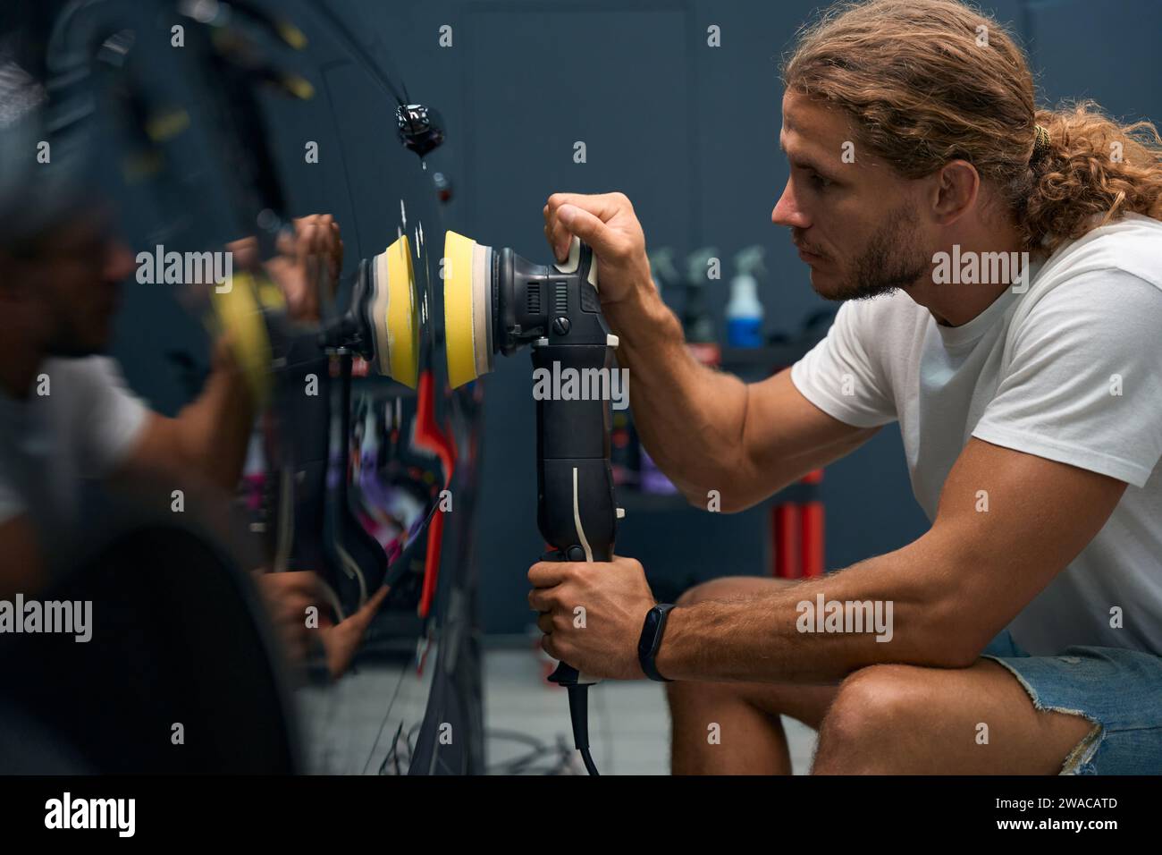Master does car detailing in a car repair shop Stock Photo - Alamy