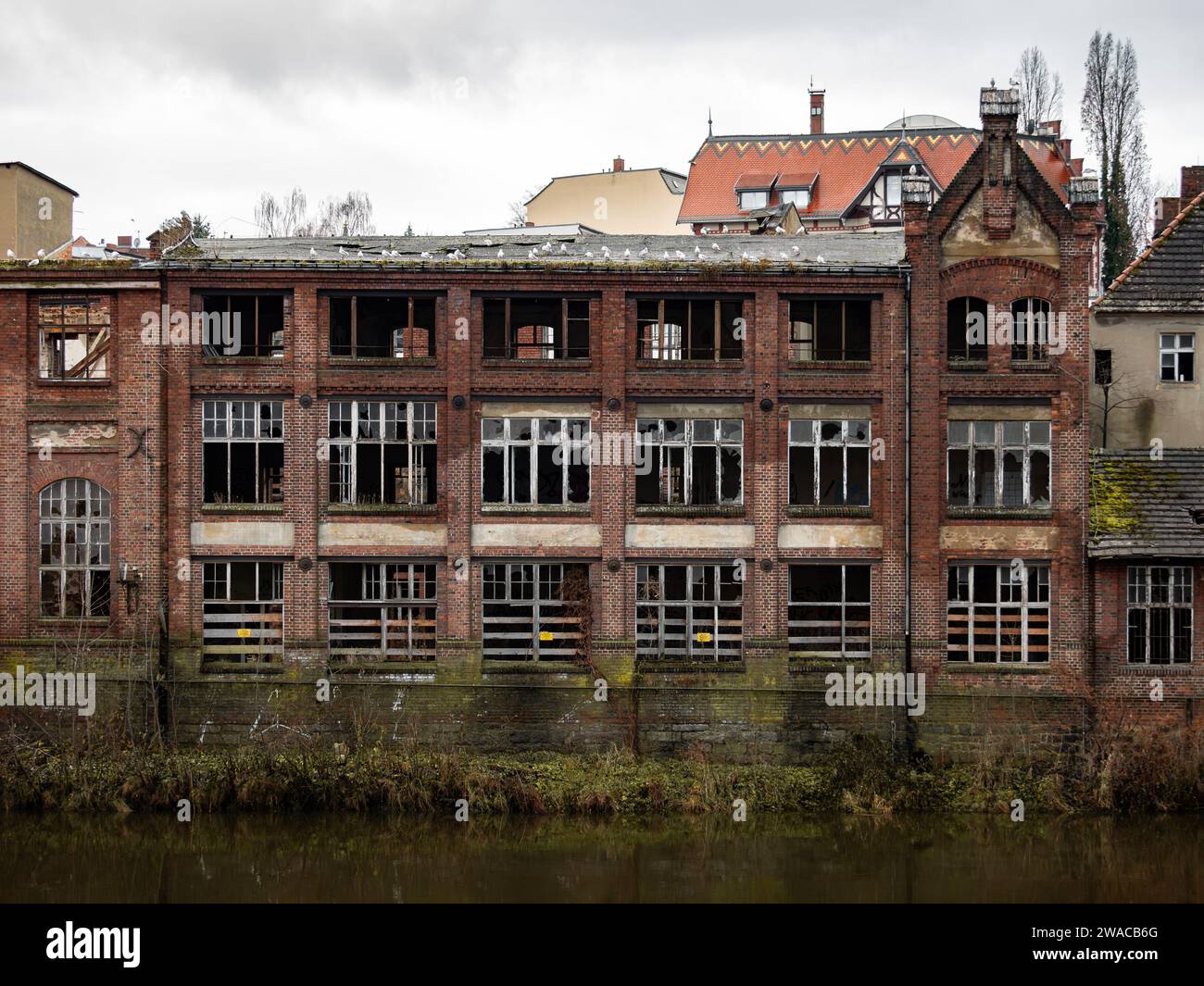 Old industrial building ruin with broken windows and a weathered exterior. The ancient factory ...