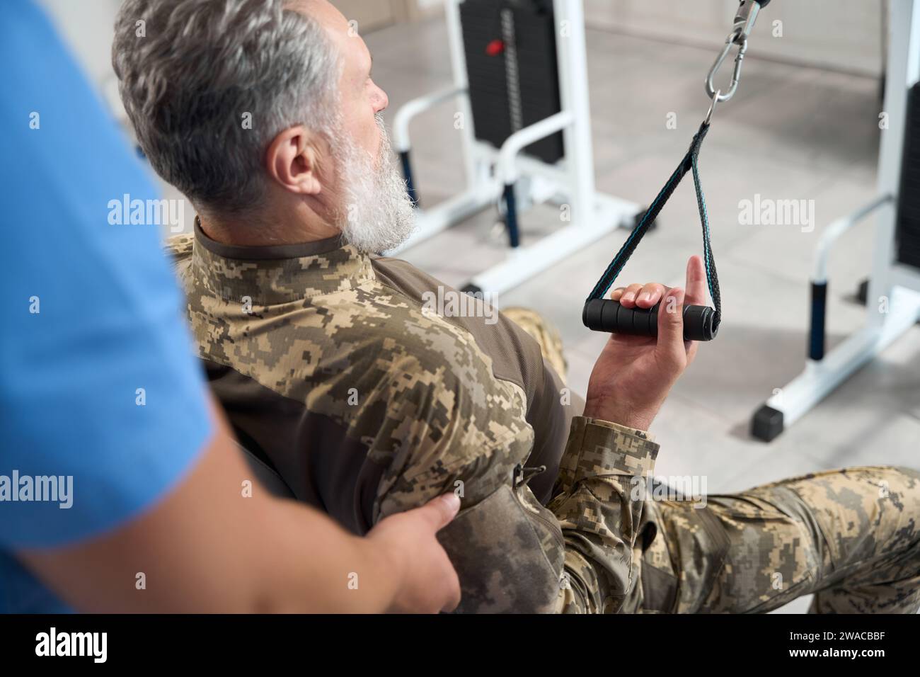 Military man in camouflage uniform performs muscle stretching exercises ...
