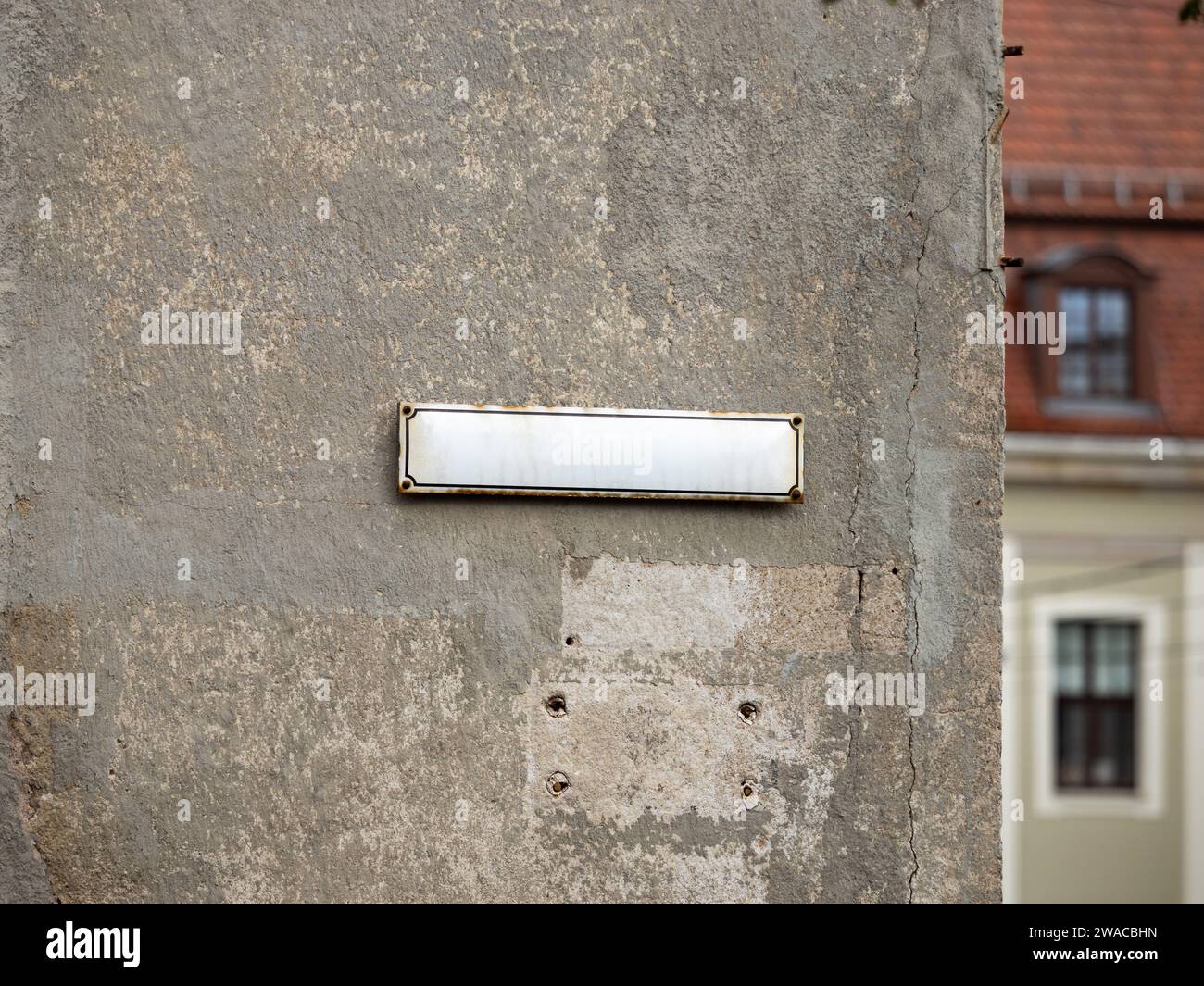 Blank road name sign on an ancient building wall. Vintage signage ...