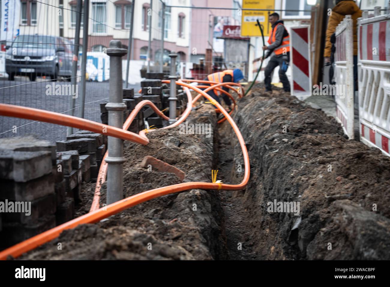 Nidda, Germany. 24th Nov, 2023. Workers lay the sheaths for fiber optic ...