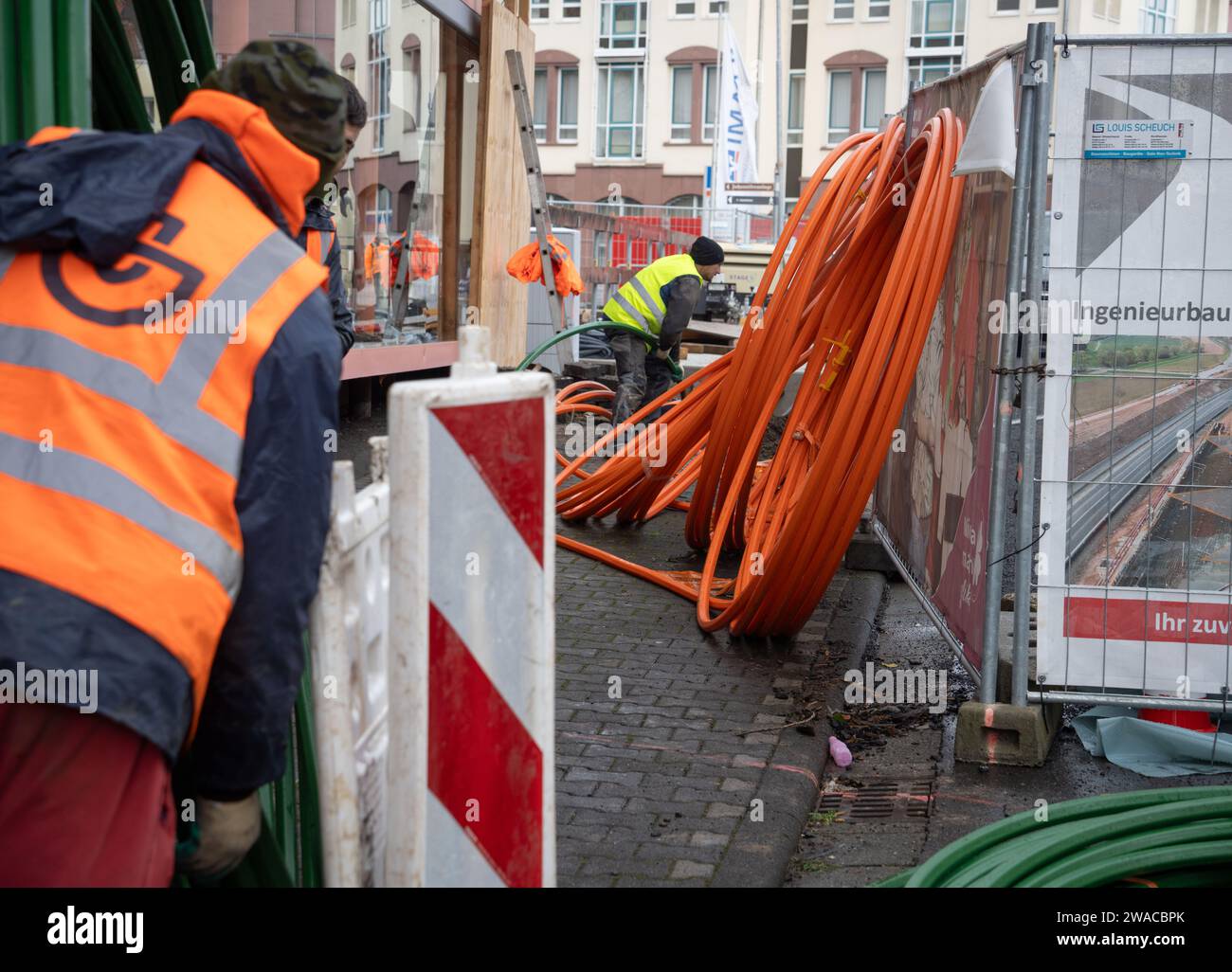Nidda, Germany. 24th Nov, 2023. Workers lay the sheaths for fiber optic ...