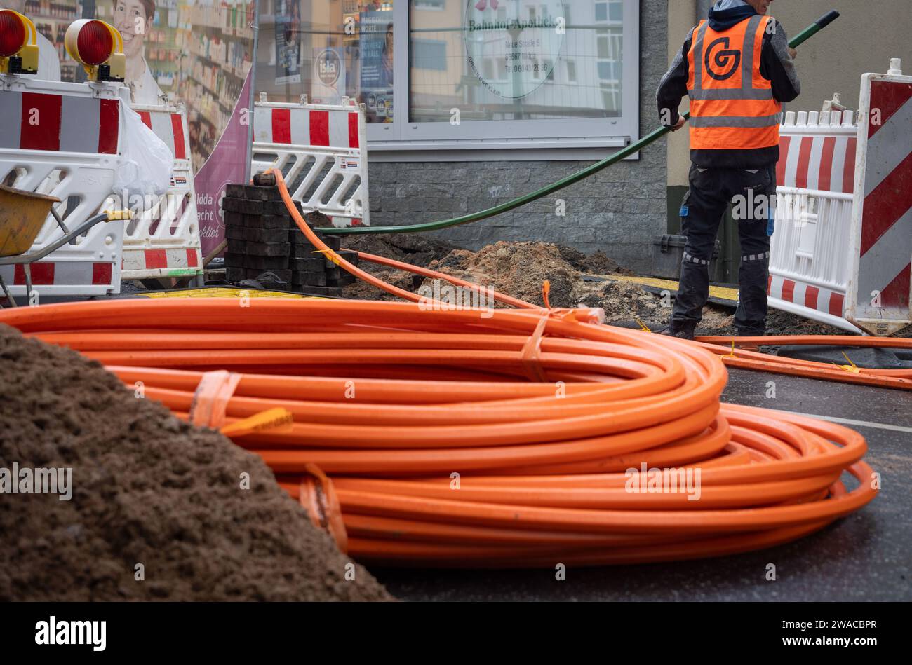 Nidda, Germany. 24th Nov, 2023. Workers lay the sheaths for fiber optic ...