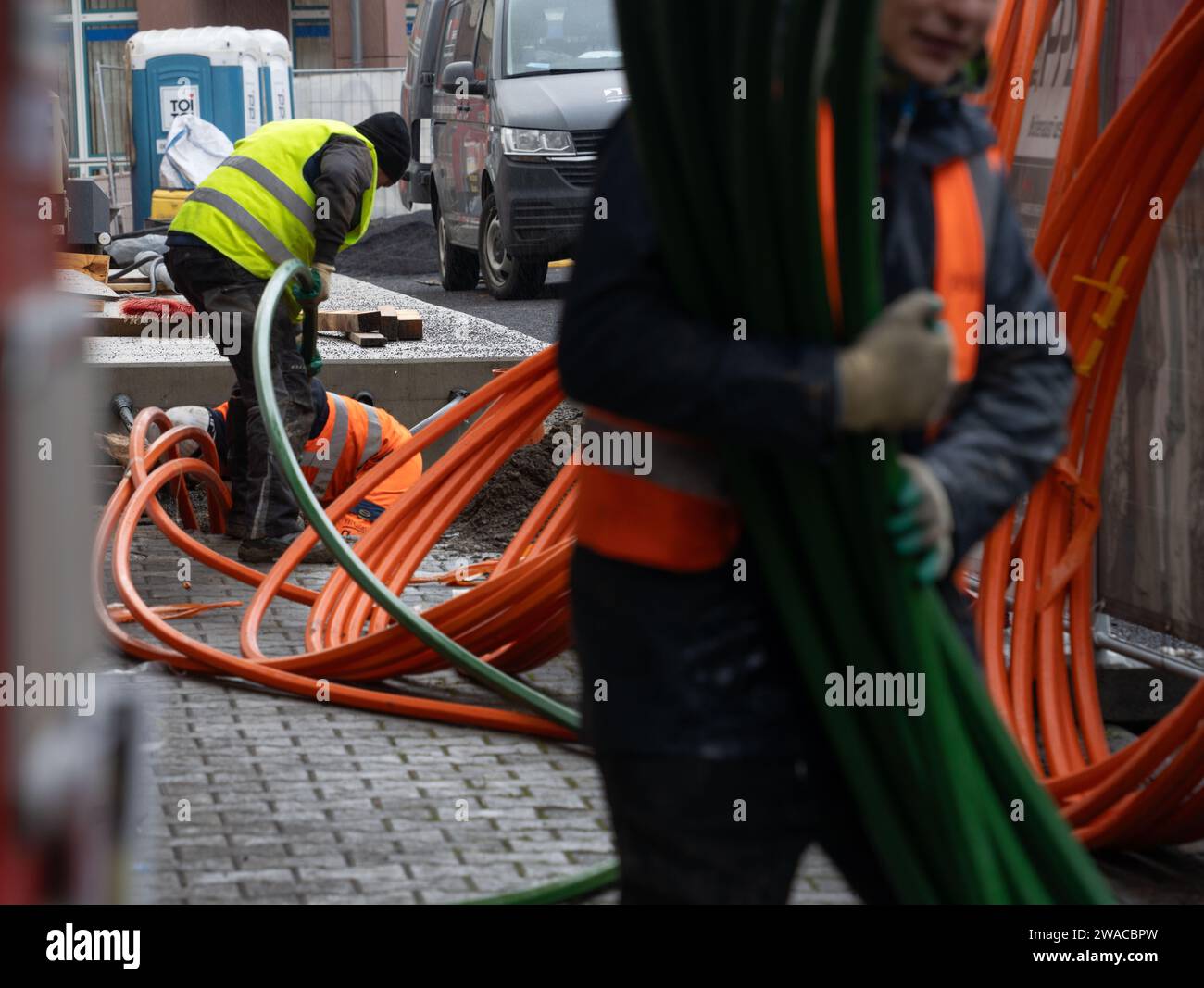 Nidda, Germany. 24th Nov, 2023. Workers lay the sheaths for fiber optic ...
