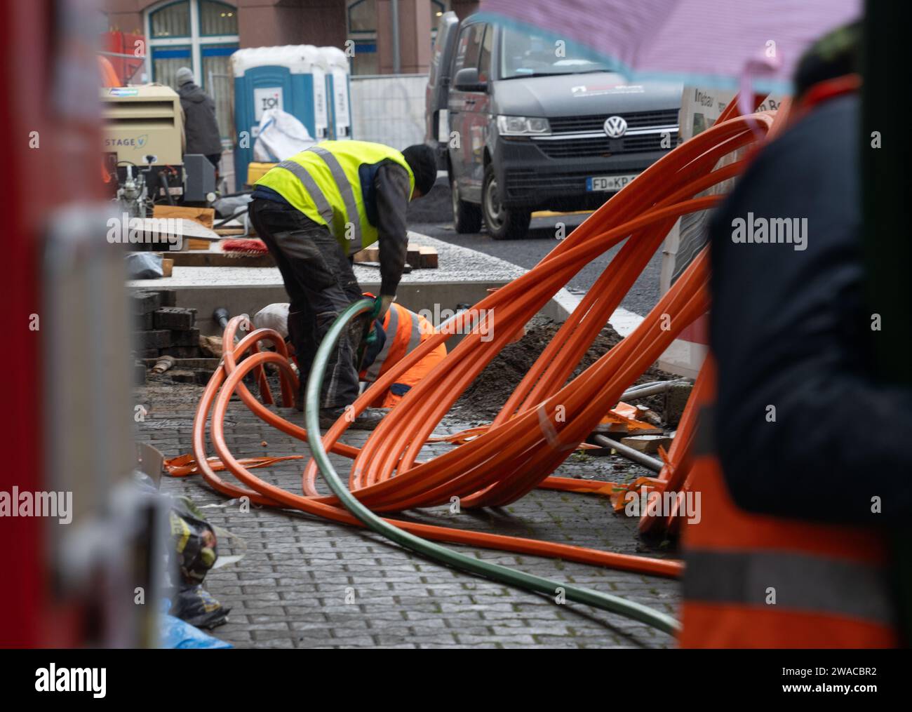 Nidda, Germany. 24th Nov, 2023. Workers lay the sheaths for fiber optic ...