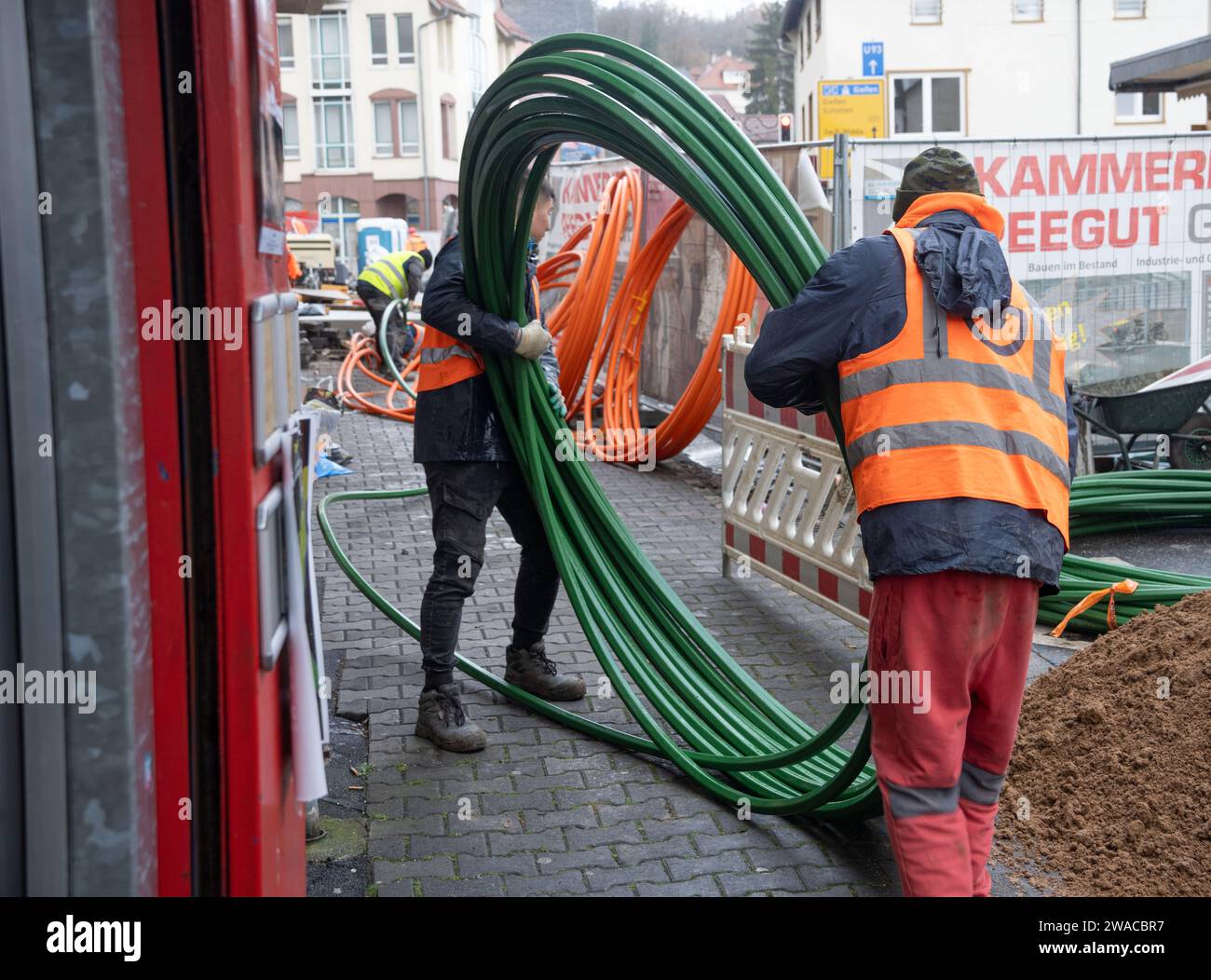 Nidda, Germany. 24th Nov, 2023. Workers lay the sheaths for fiber optic ...