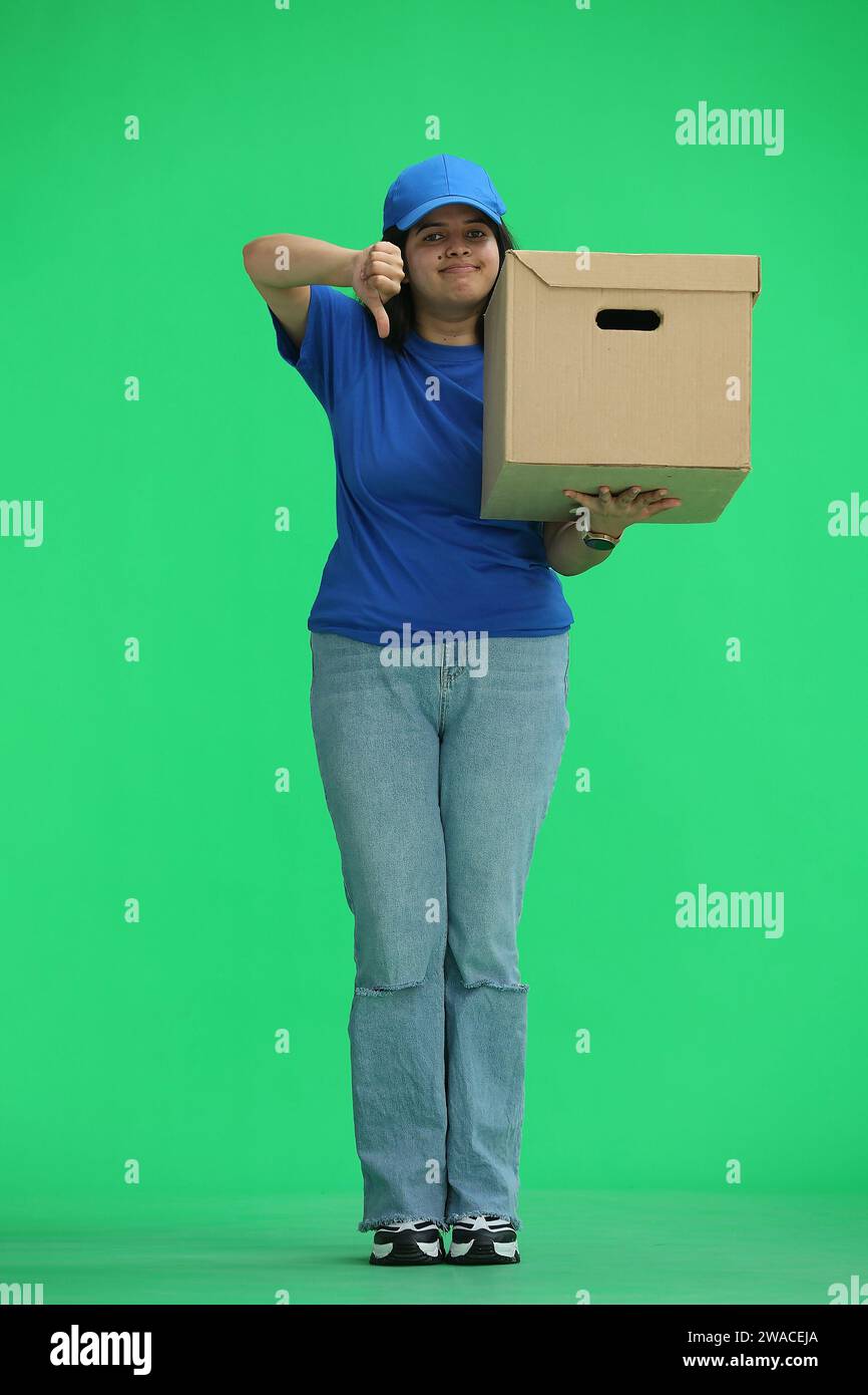 A delivery woman with a box, on a green background, in full height ...