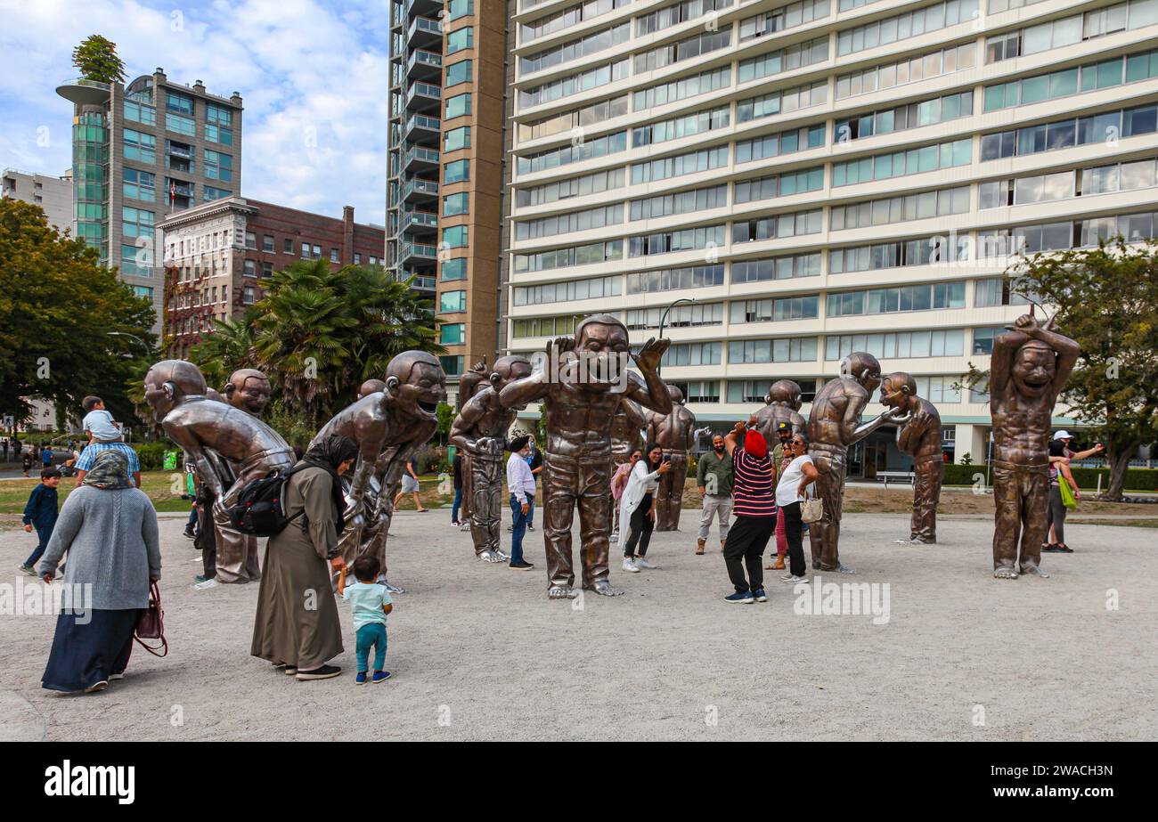 A group of visitors interacting with Chinese sculptor Yue Minjun's 2009 ...