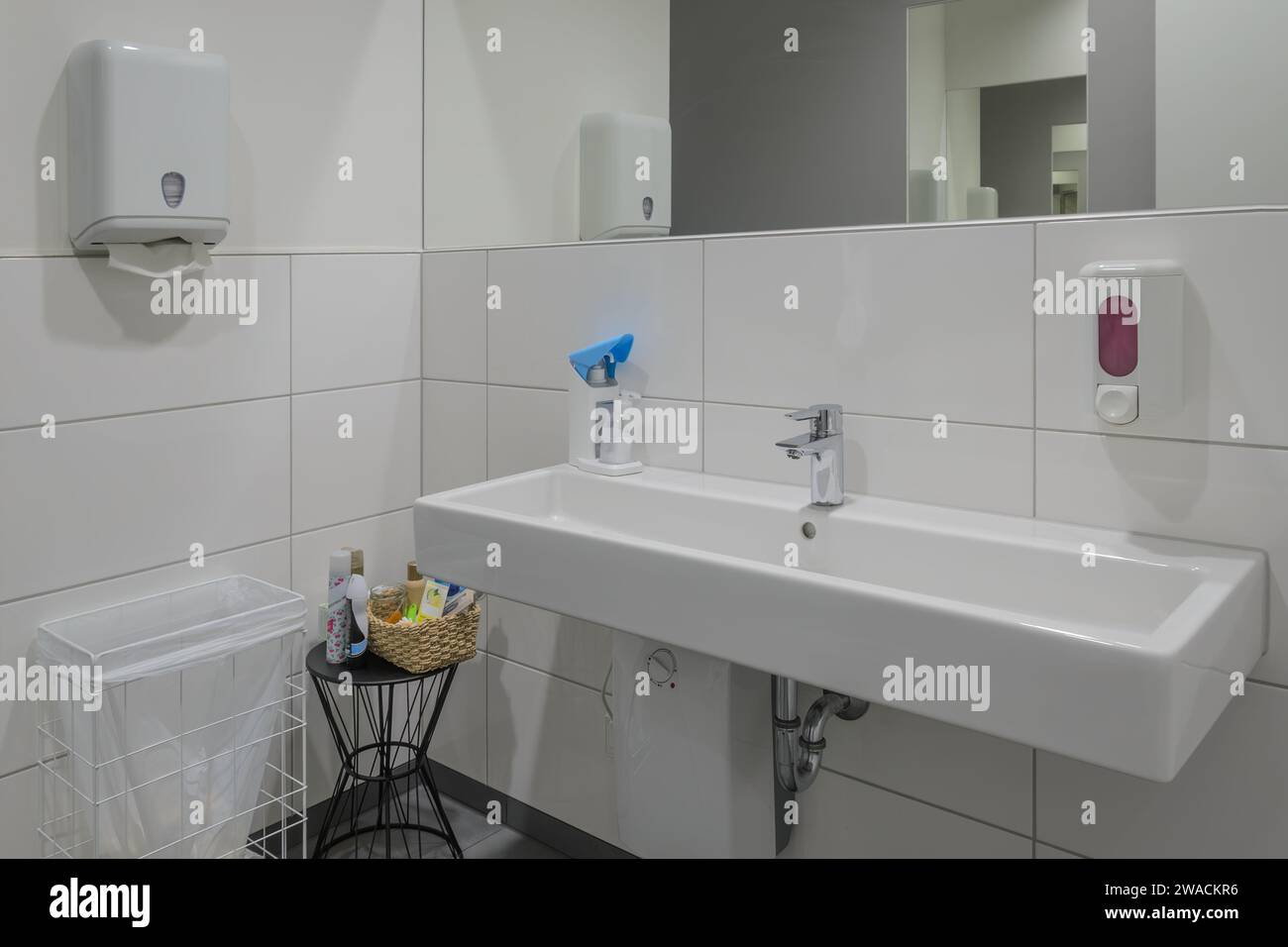pristine modern bathroom featuring long white sink, hand dryer, and ...