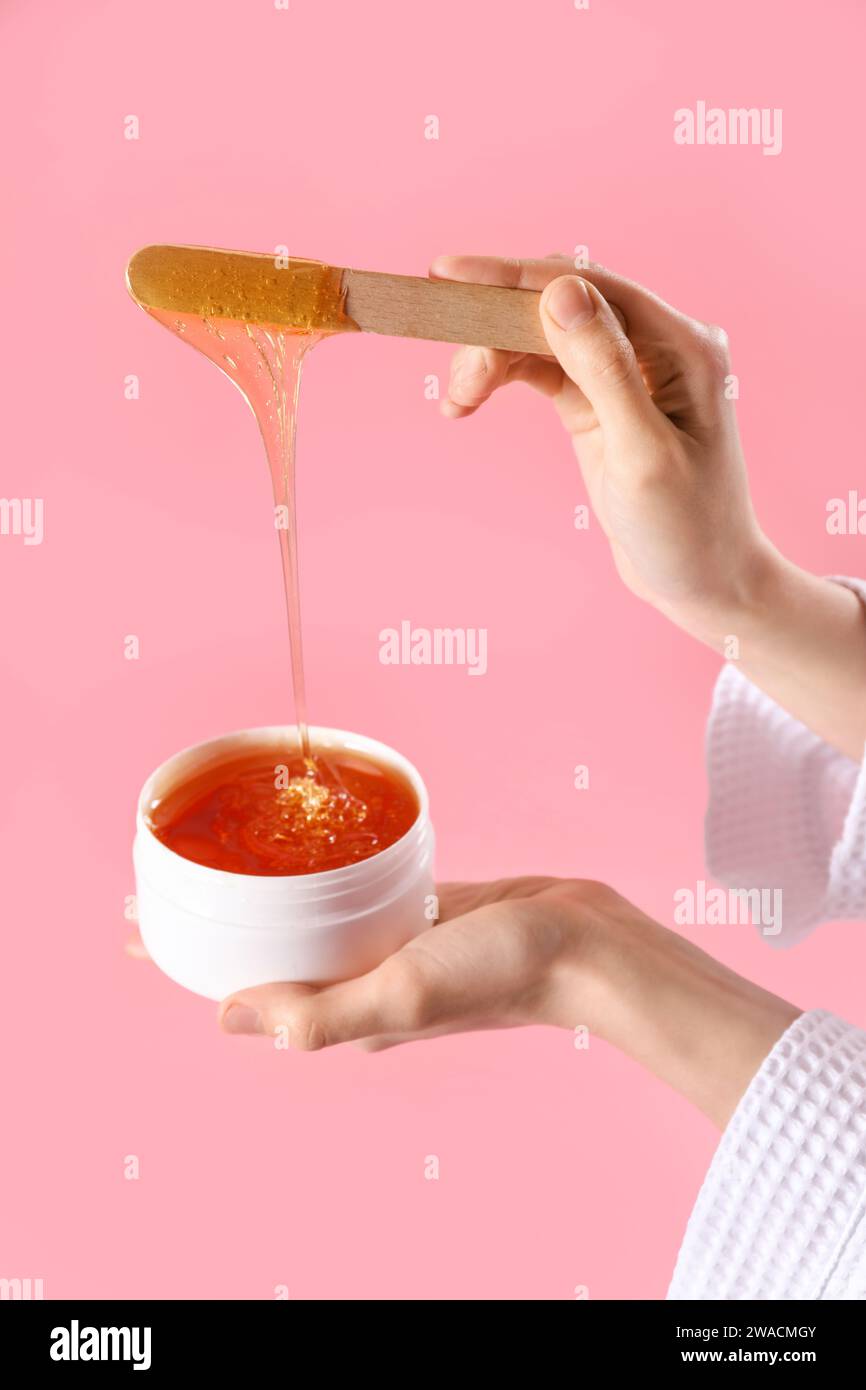 Hands with sugaring paste on pink background Stock Photo - Alamy