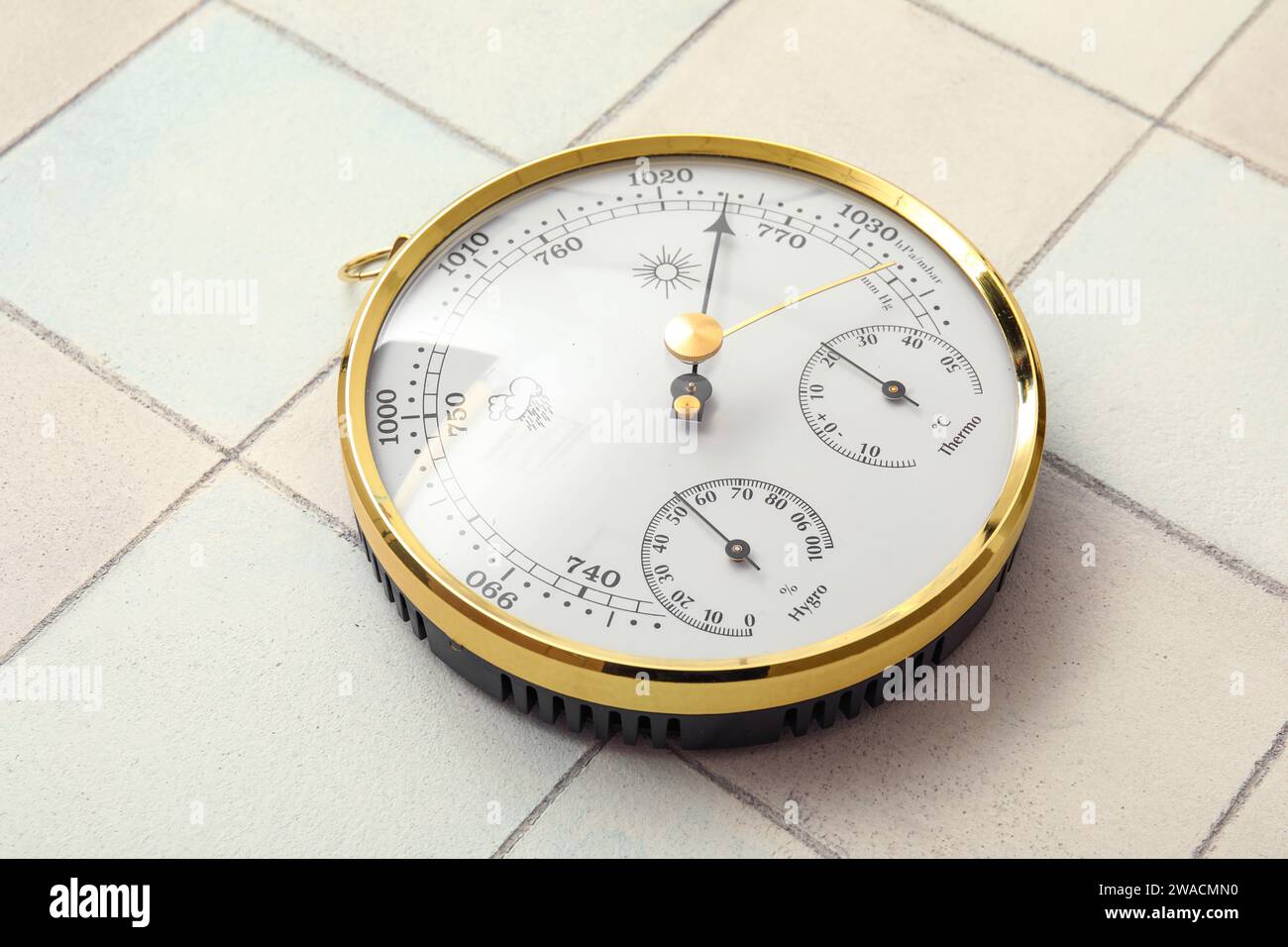 Aneroid barometer on white tiled background Stock Photo - Alamy