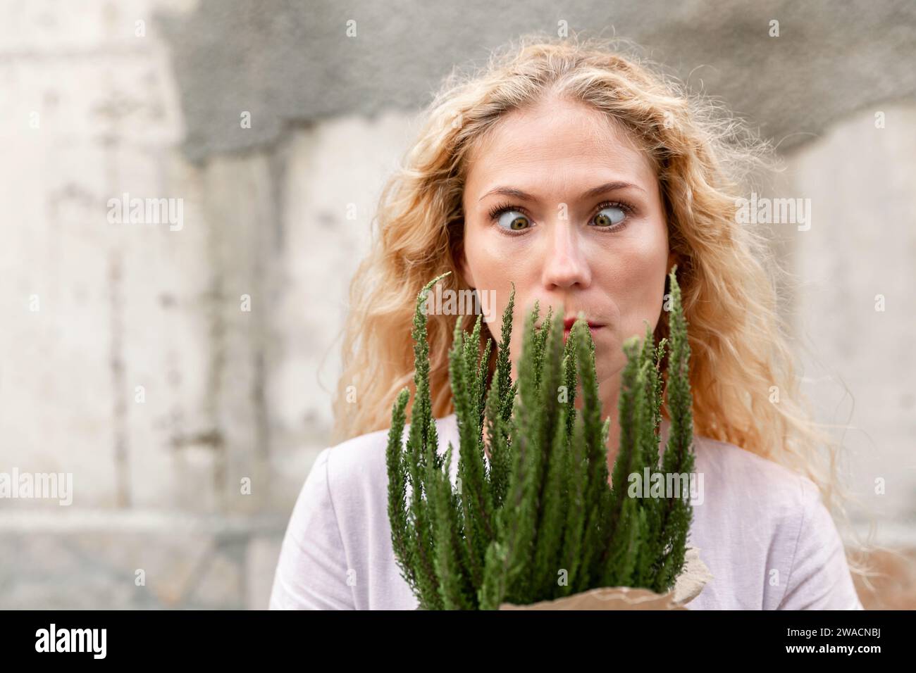 Funny blonde woman making grimace with crossed green eyes Stock Photo ...