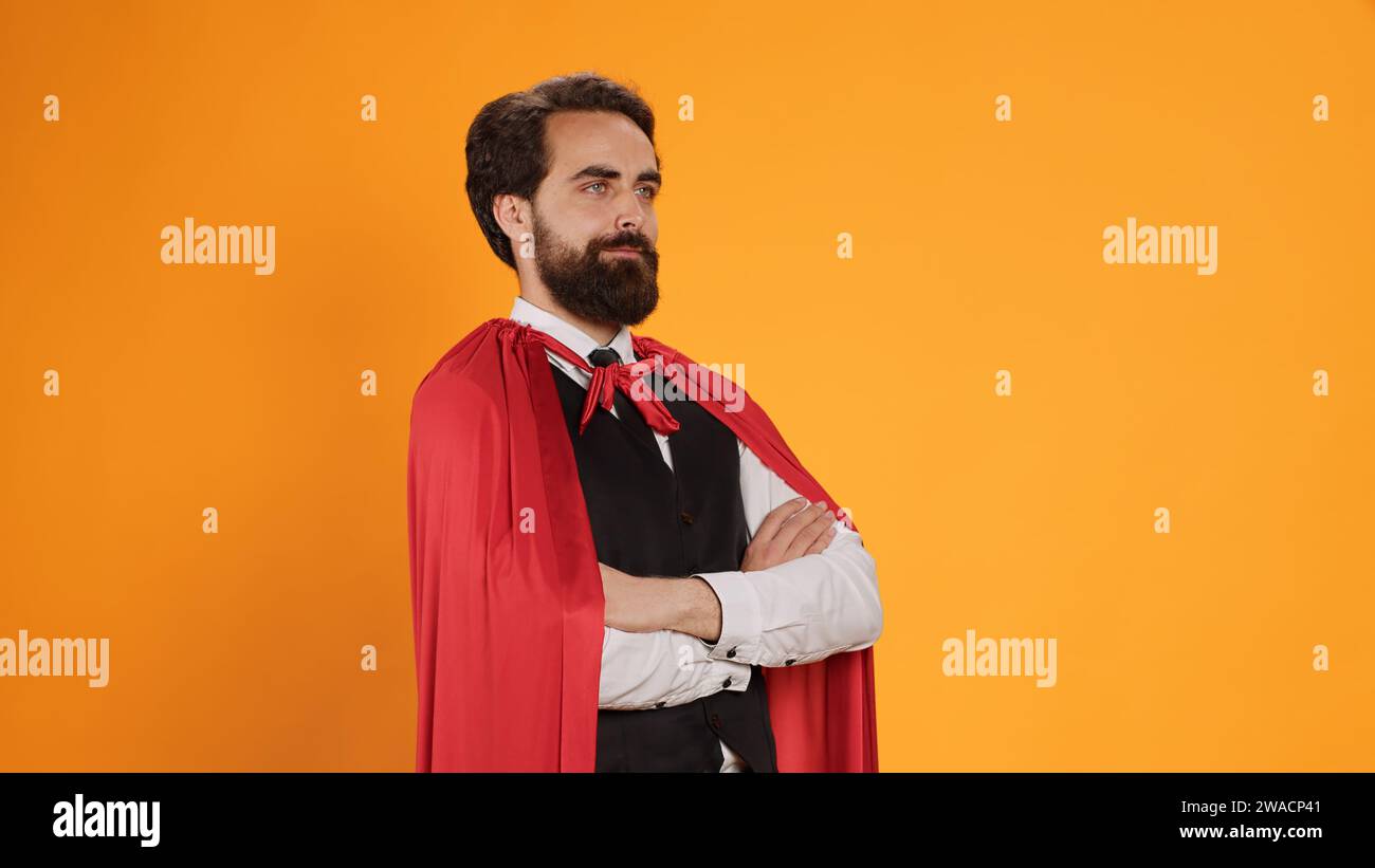 Powerful fantasy hero with red cape standing against yellow background ...