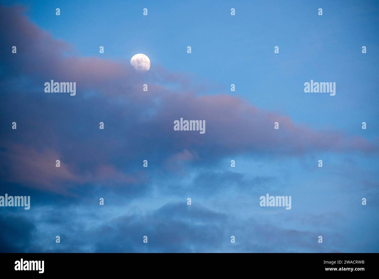 The full moon rises behind colorful clouds in Woodland, CA, USA in ...