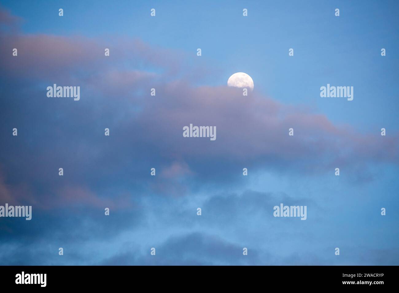 The full moon rises behind colorful clouds in Woodland, CA, USA in ...