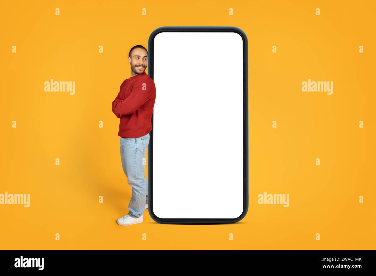 Curious millennial man looking at big phone screen Stock Photo - Alamy