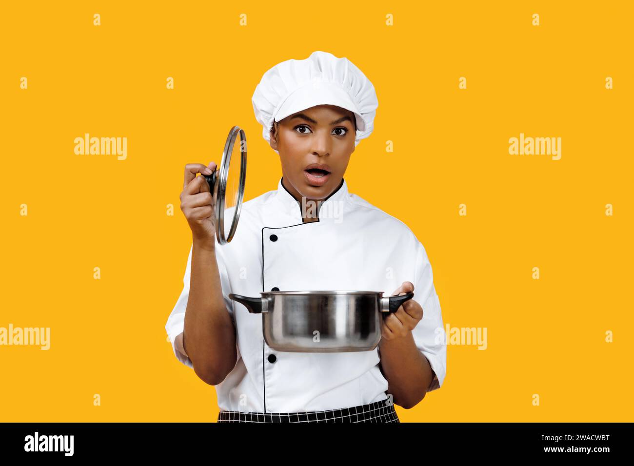 Happy chef lifting a lid off a pot in a commercial kitchen Stock Photo ...