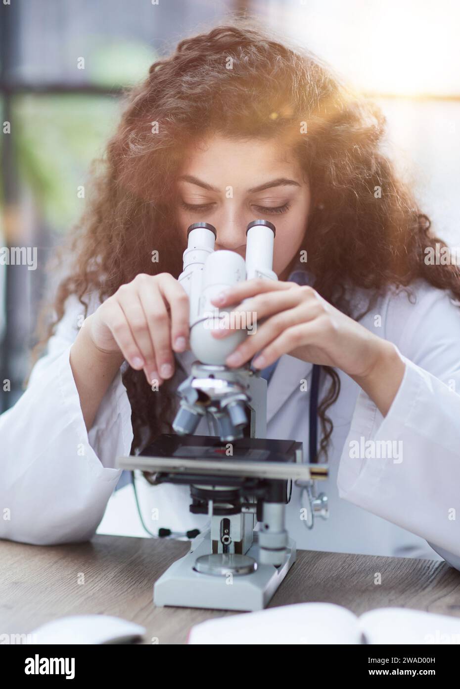 Attractive female scientist looking through a microscope Stock Photo ...