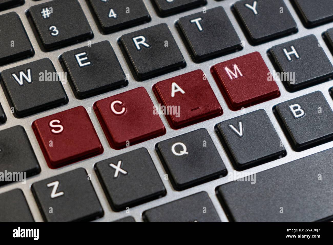 A computer keyboard with red keys spelling the word scam Stock Photo - Alamy