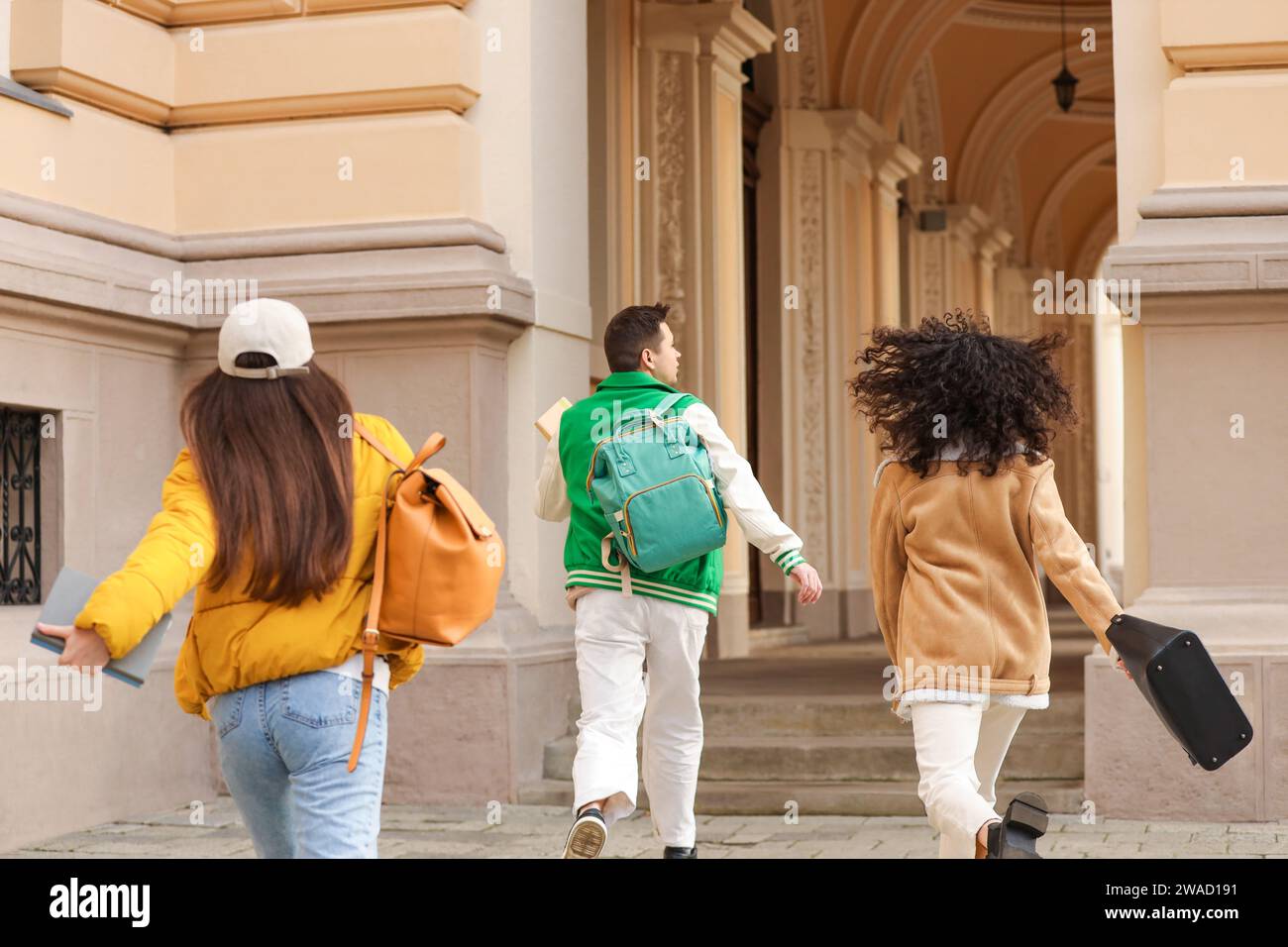 Being late. Group of students running towards building outdoors, back ...