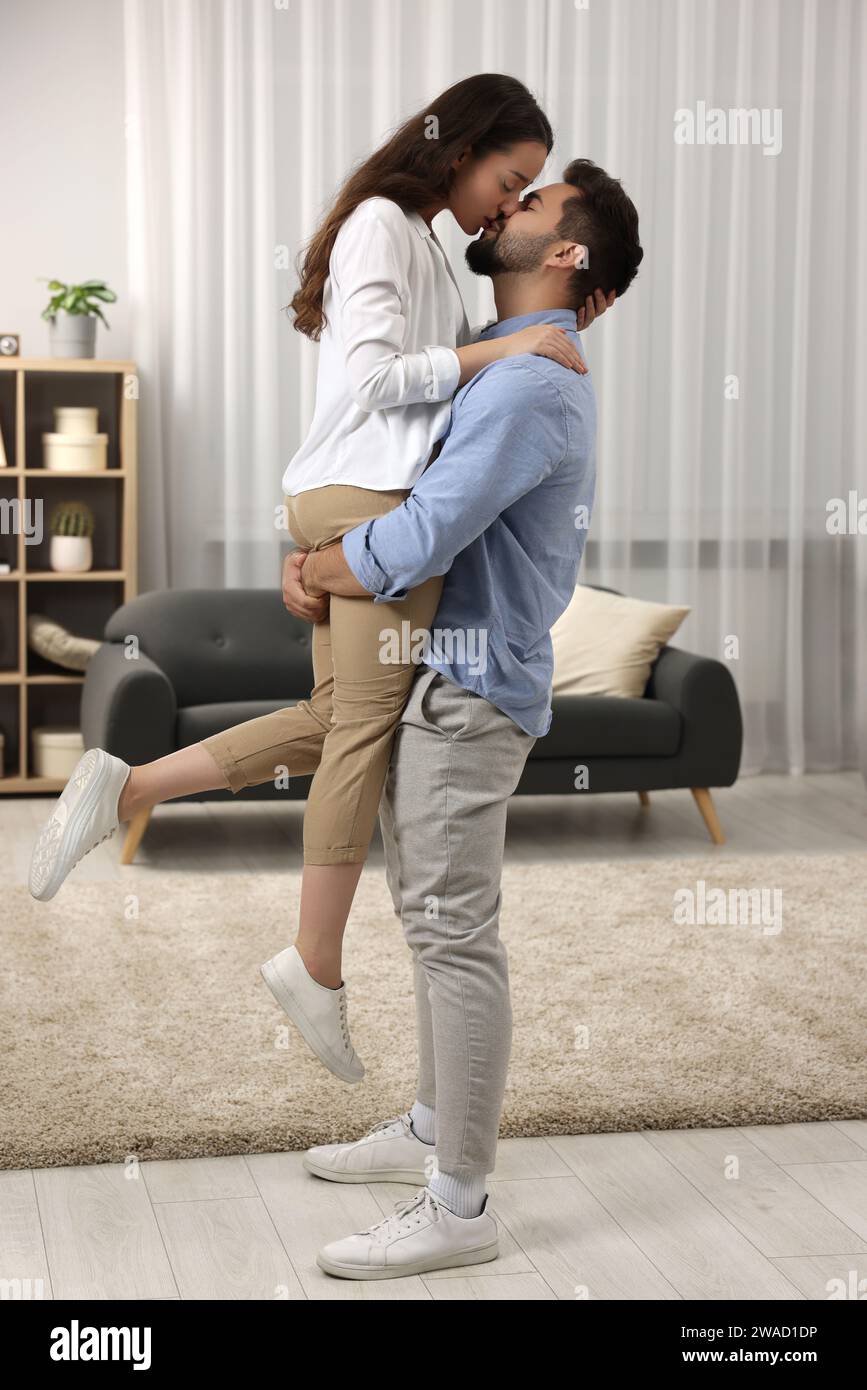 Love relationship. Passionate young couple kissing at home Stock Photo ...