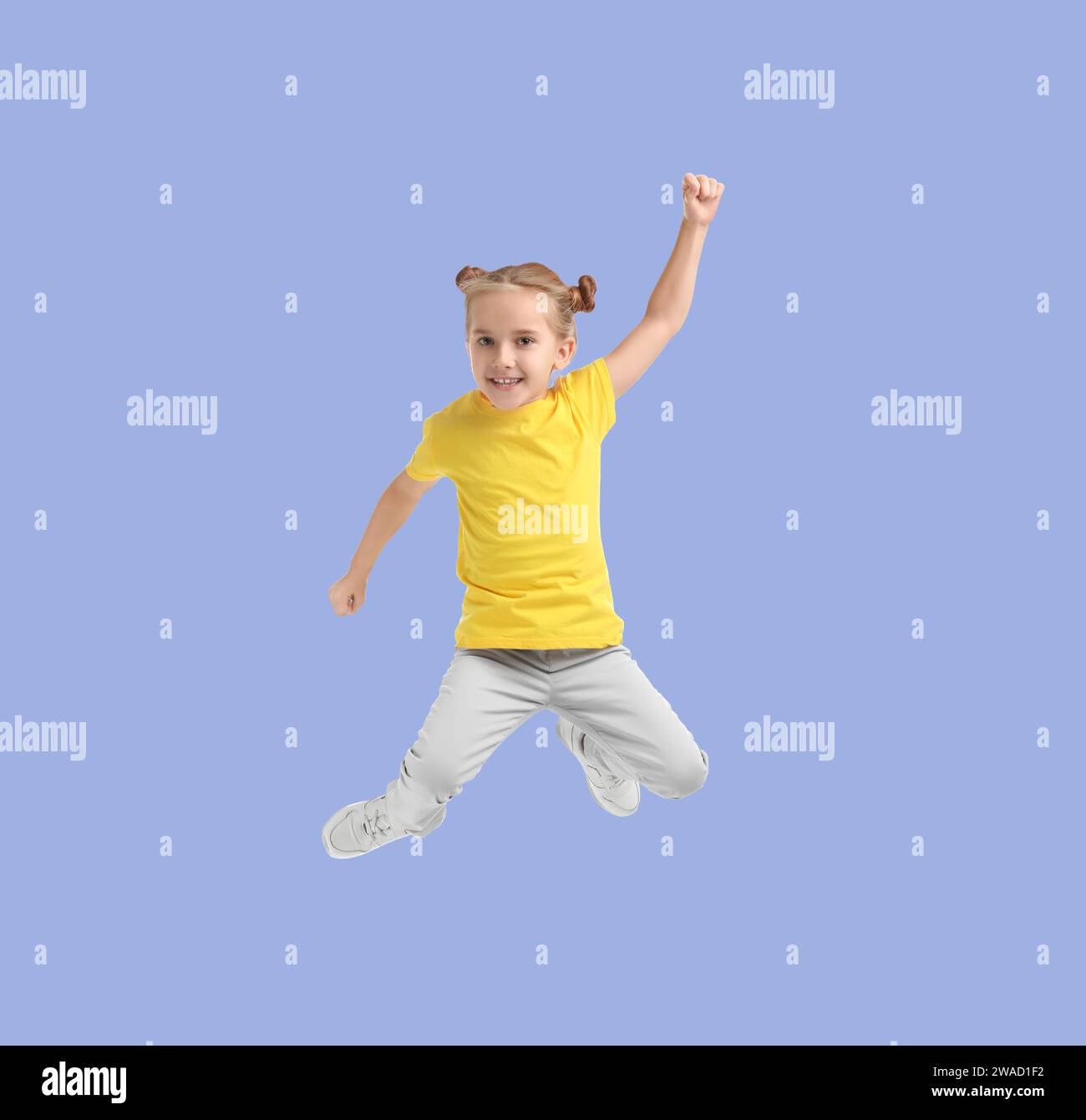 Happy cute girl jumping on light blue background Stock Photo - Alamy
