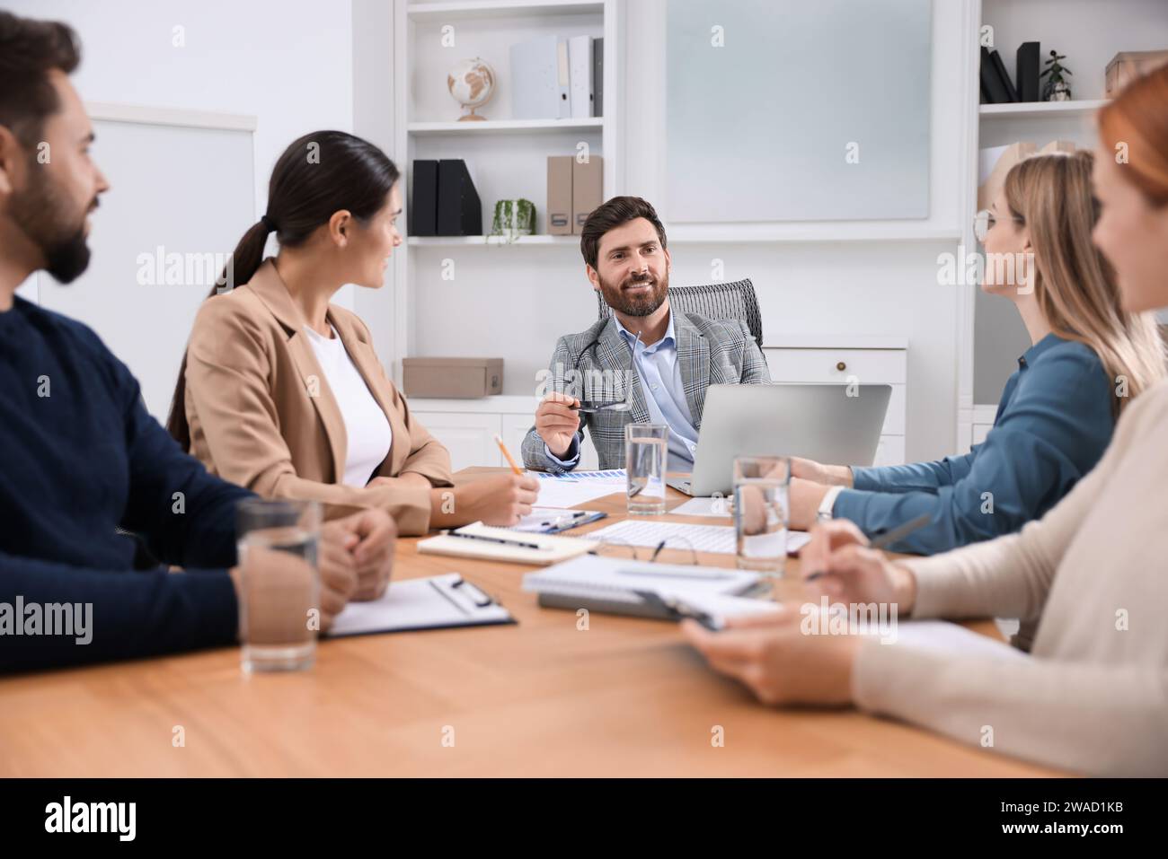 Team of employees working together in office Stock Photo - Alamy
